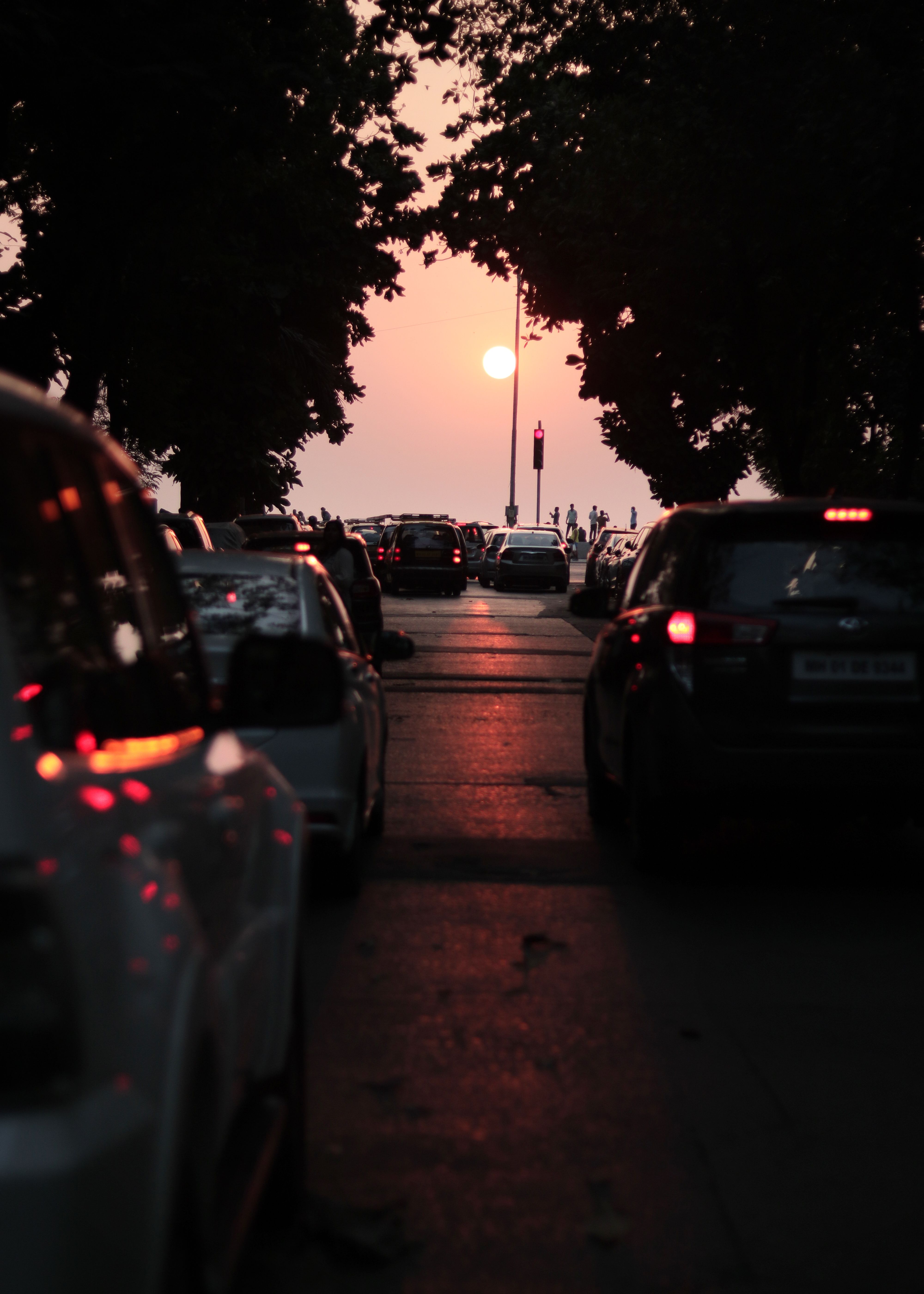 A sunset over a city street with cars parked · Free Stock Photo