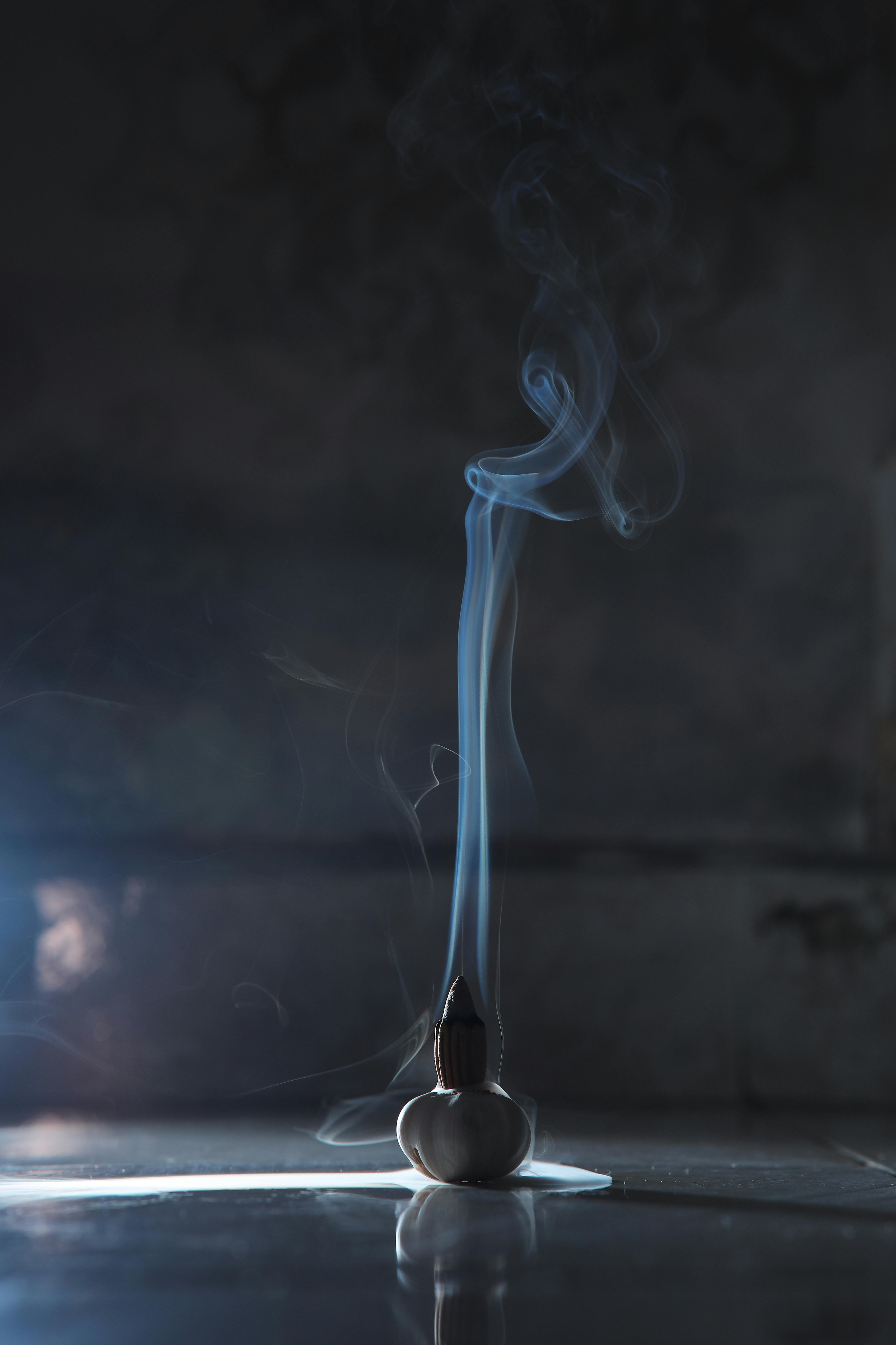A small incense stick with smoke coming out of it · Free Stock Photo