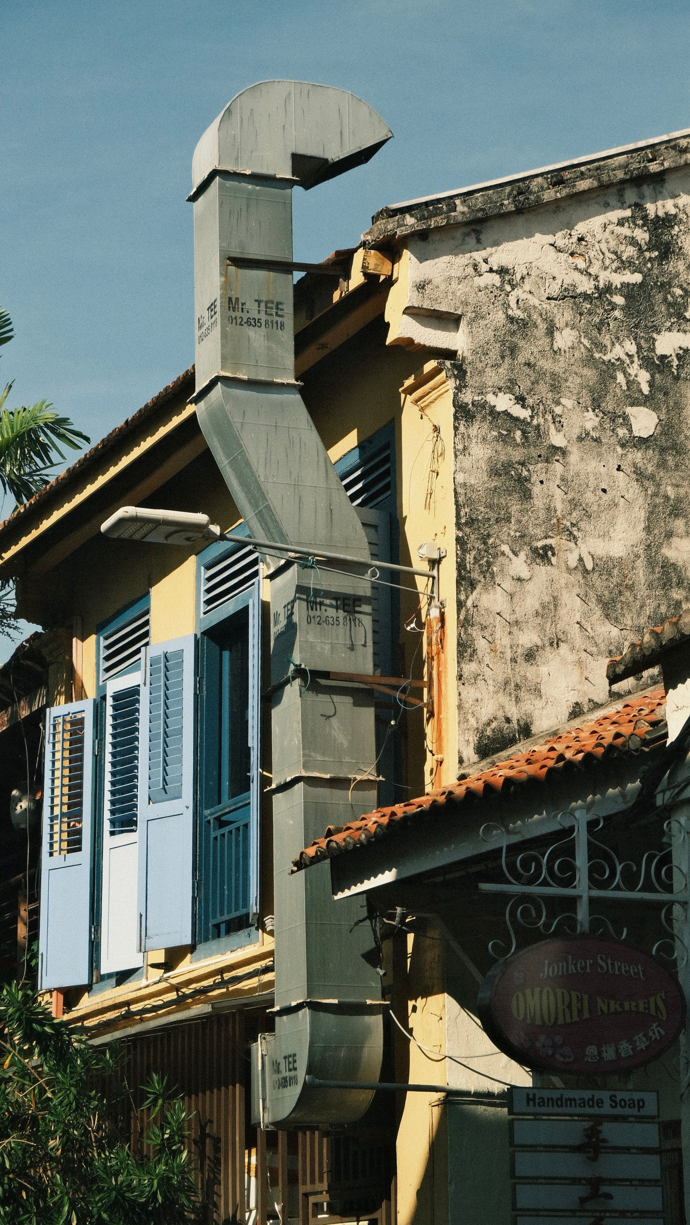 View of Exterior of an Old House with a Large Pipe · Free Stock Photo