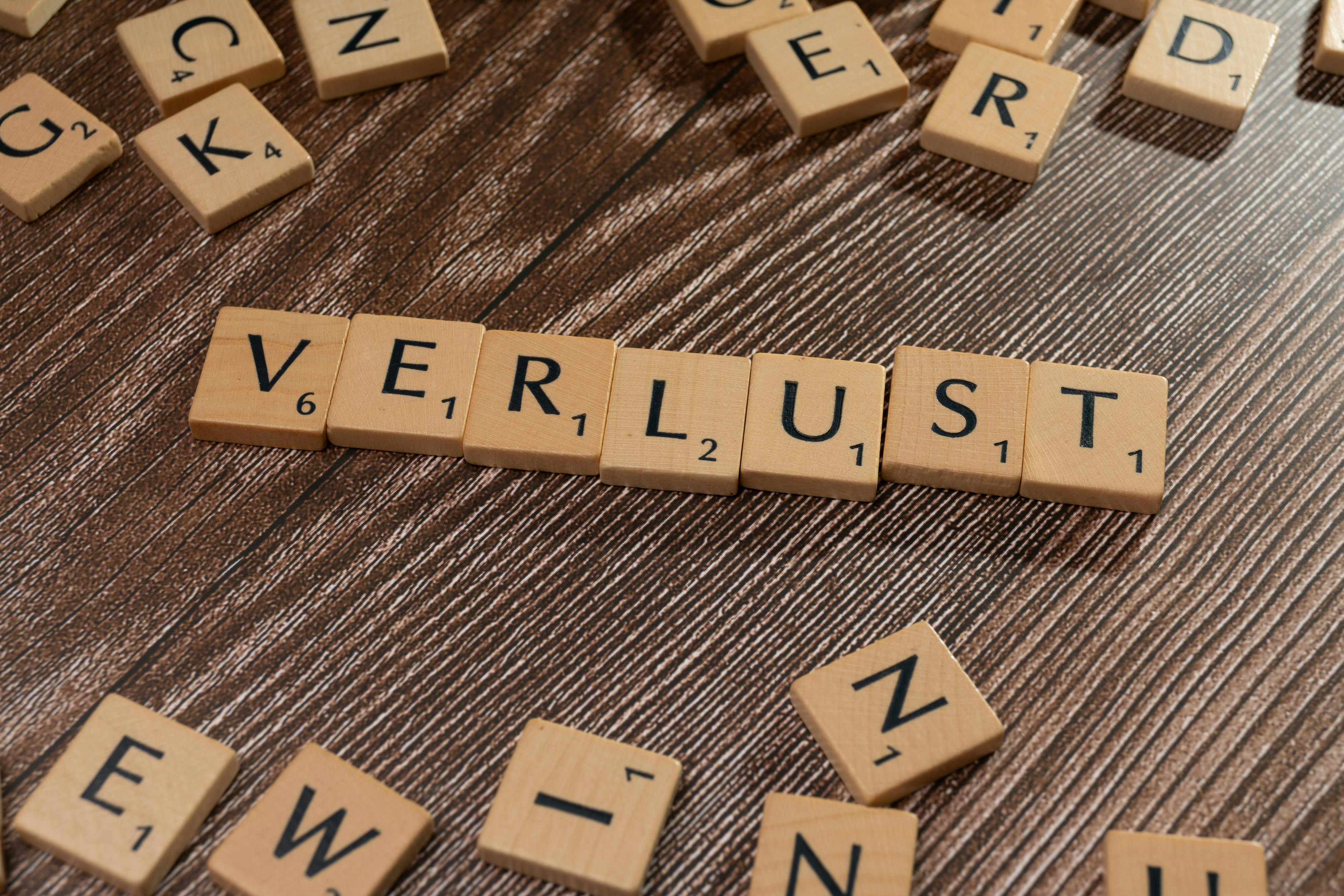 The word verlust is spelled out in scrabble tiles · Free Stock Photo