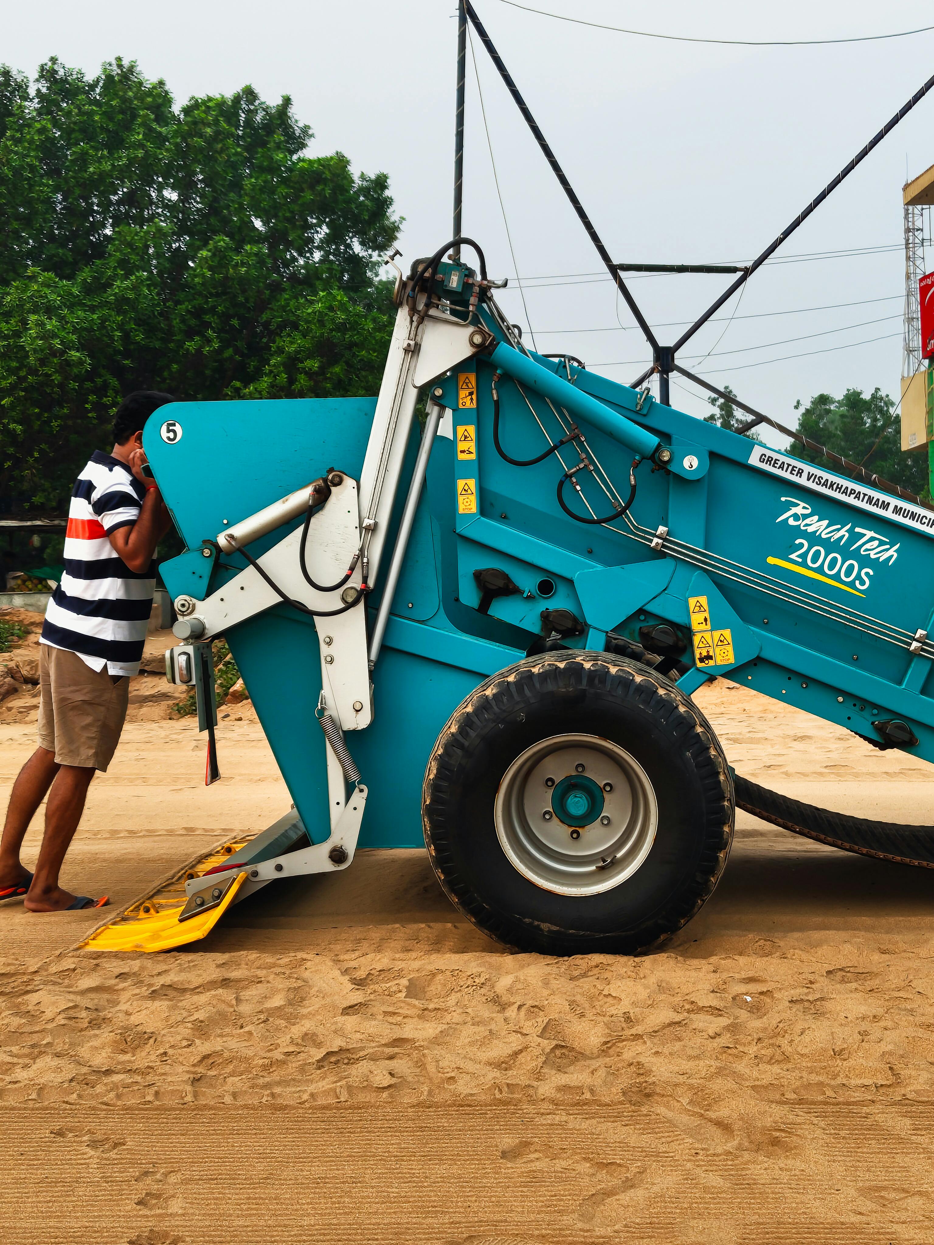 Man Operating a Beach Cleaning Machine · Free Stock Photo