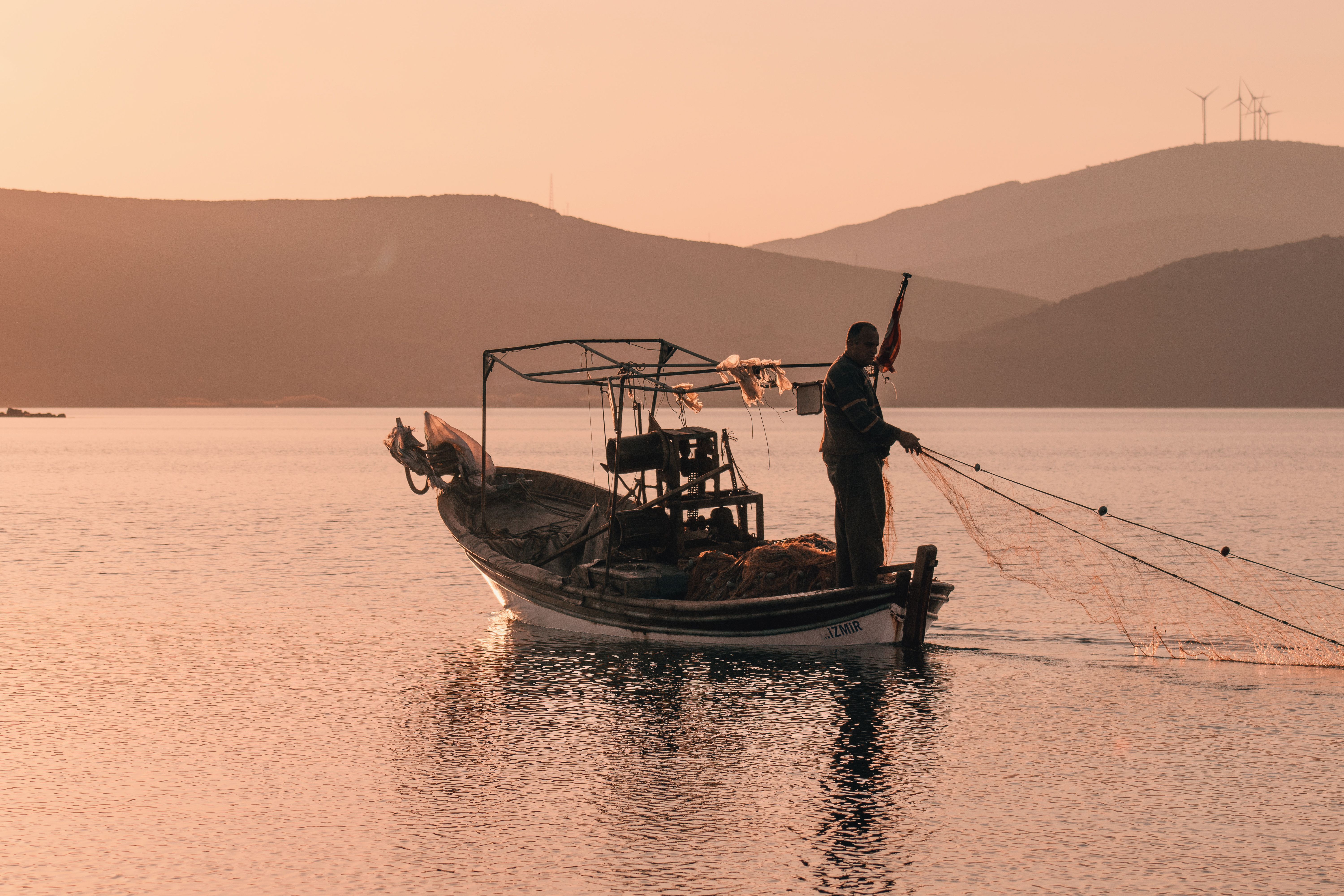 Fisherman on Boat at Sunset · Free Stock Photo
