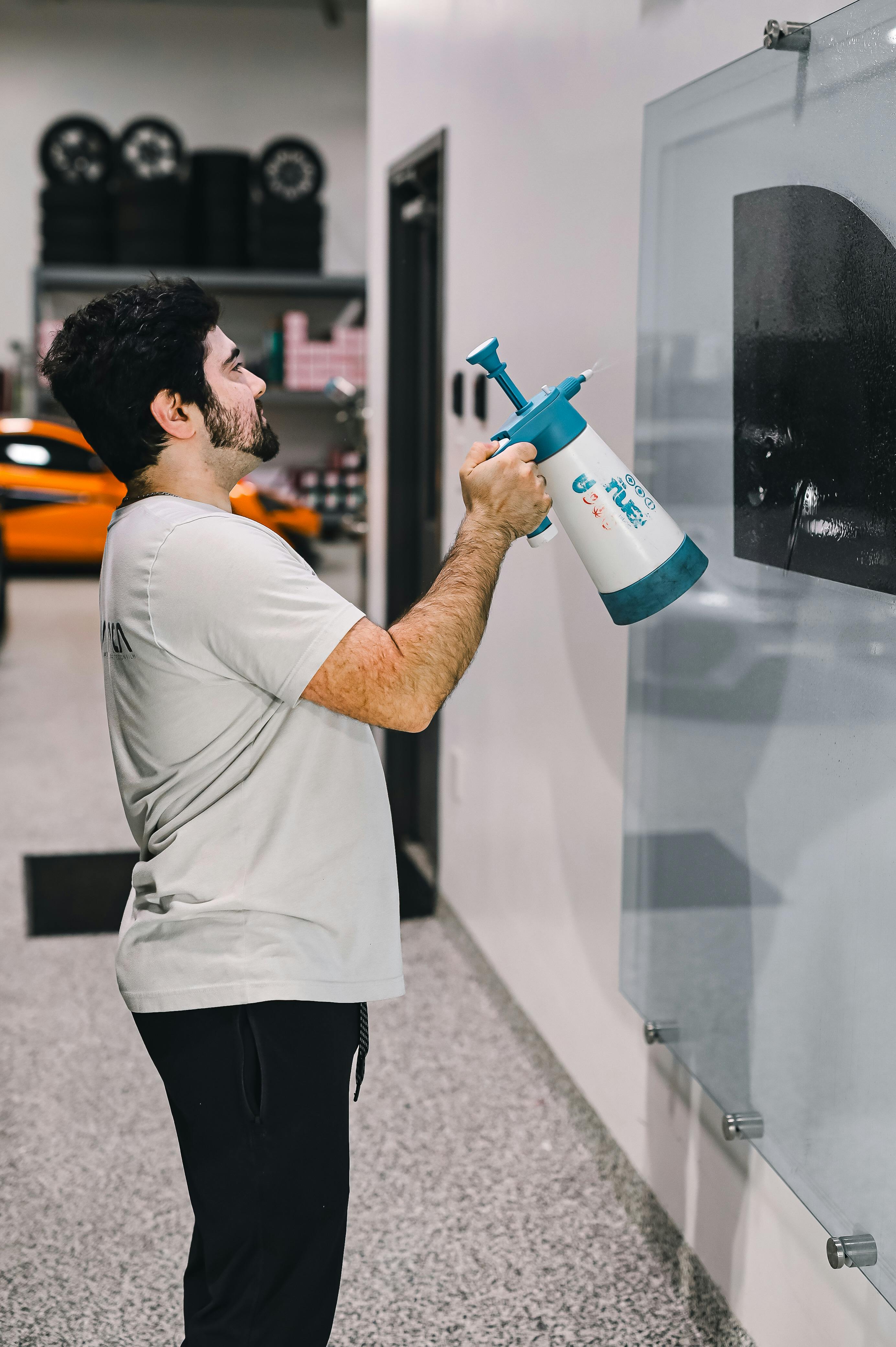 Man Spraying and Cleaning Wall · Free Stock Photo