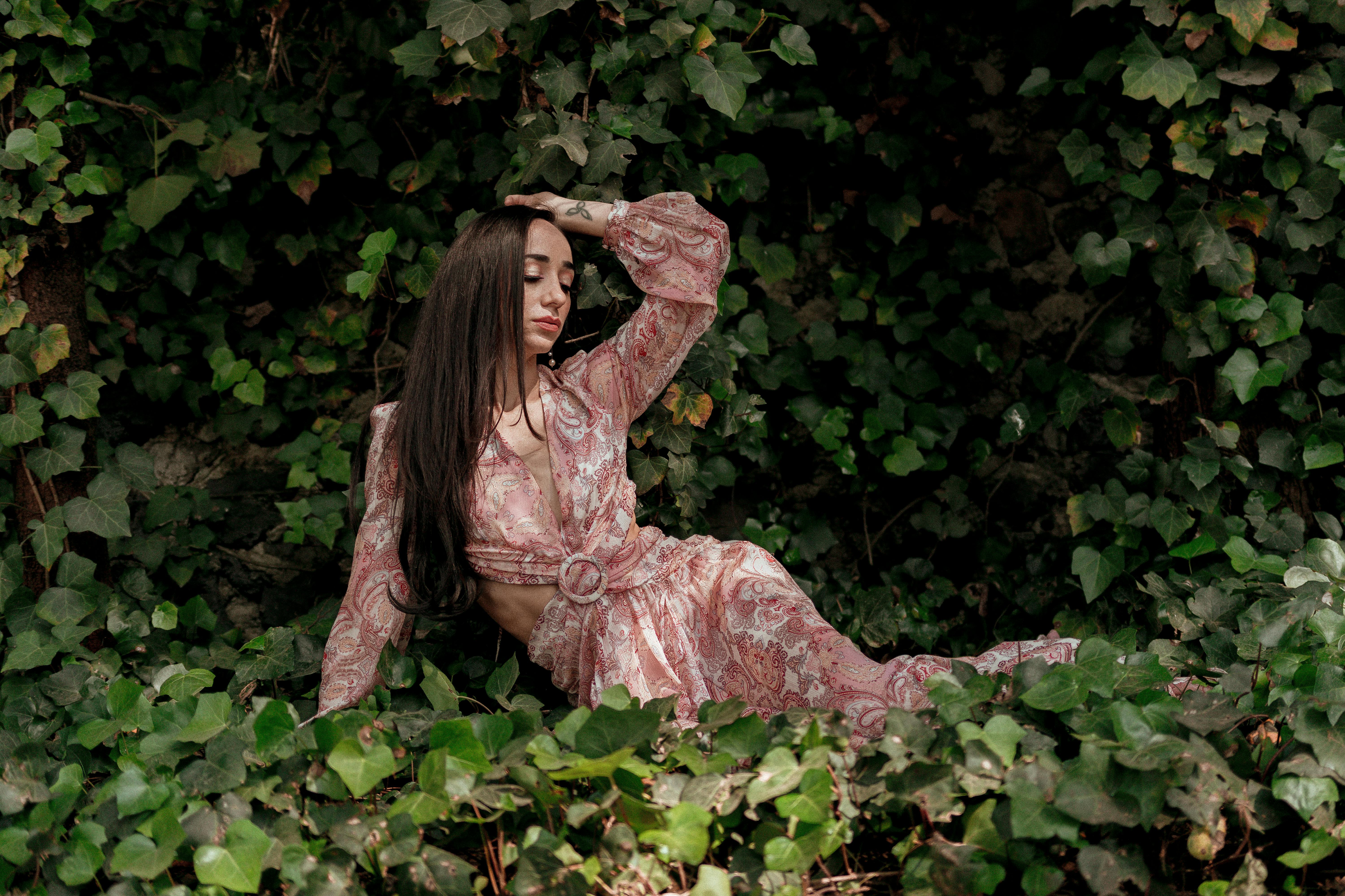 Woman in Dress Lying Down among Bush Leaves · Free Stock Photo