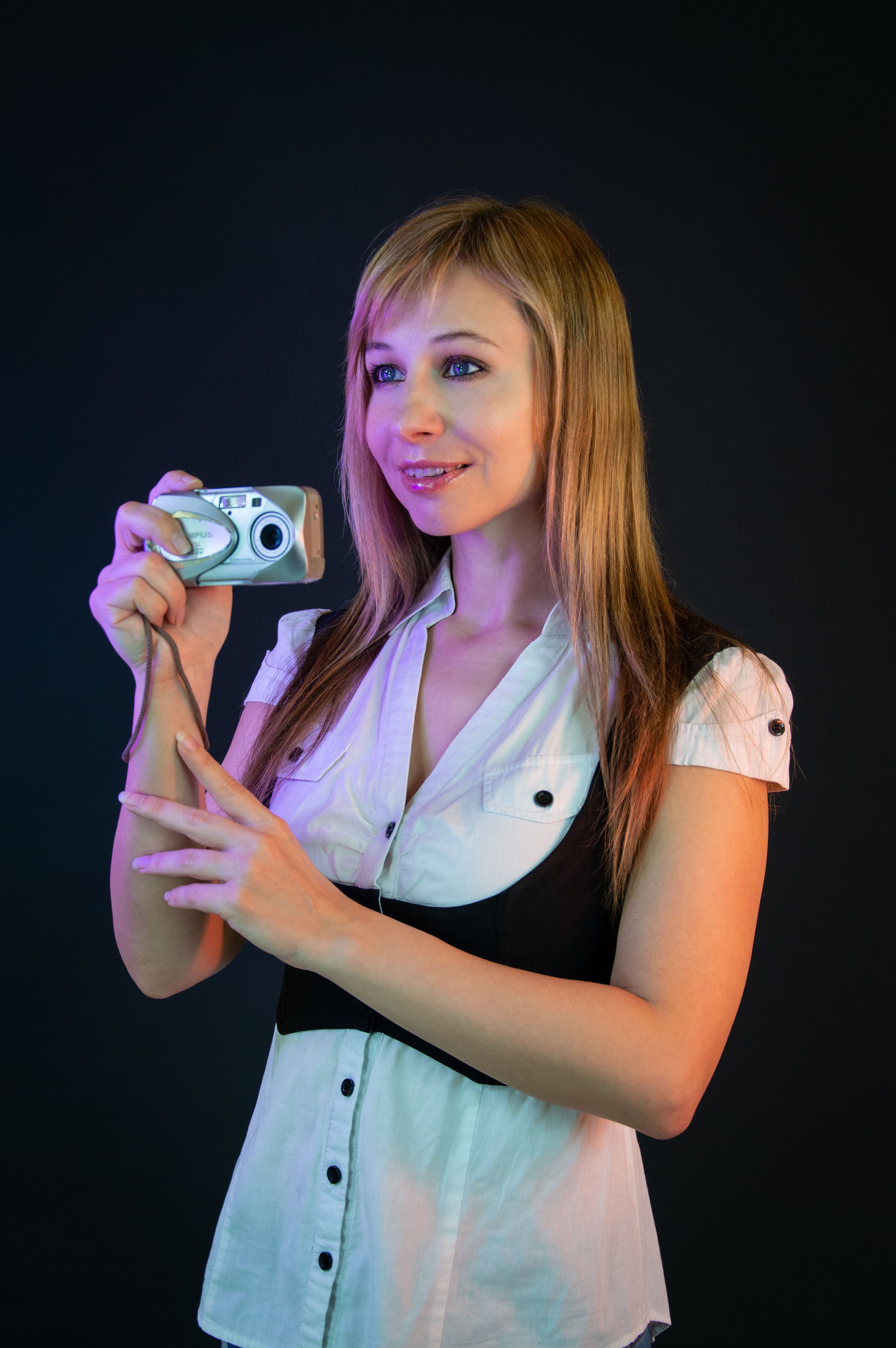 Studio Shot of Model in White Blouse Holding Camera · Free Stock Photo