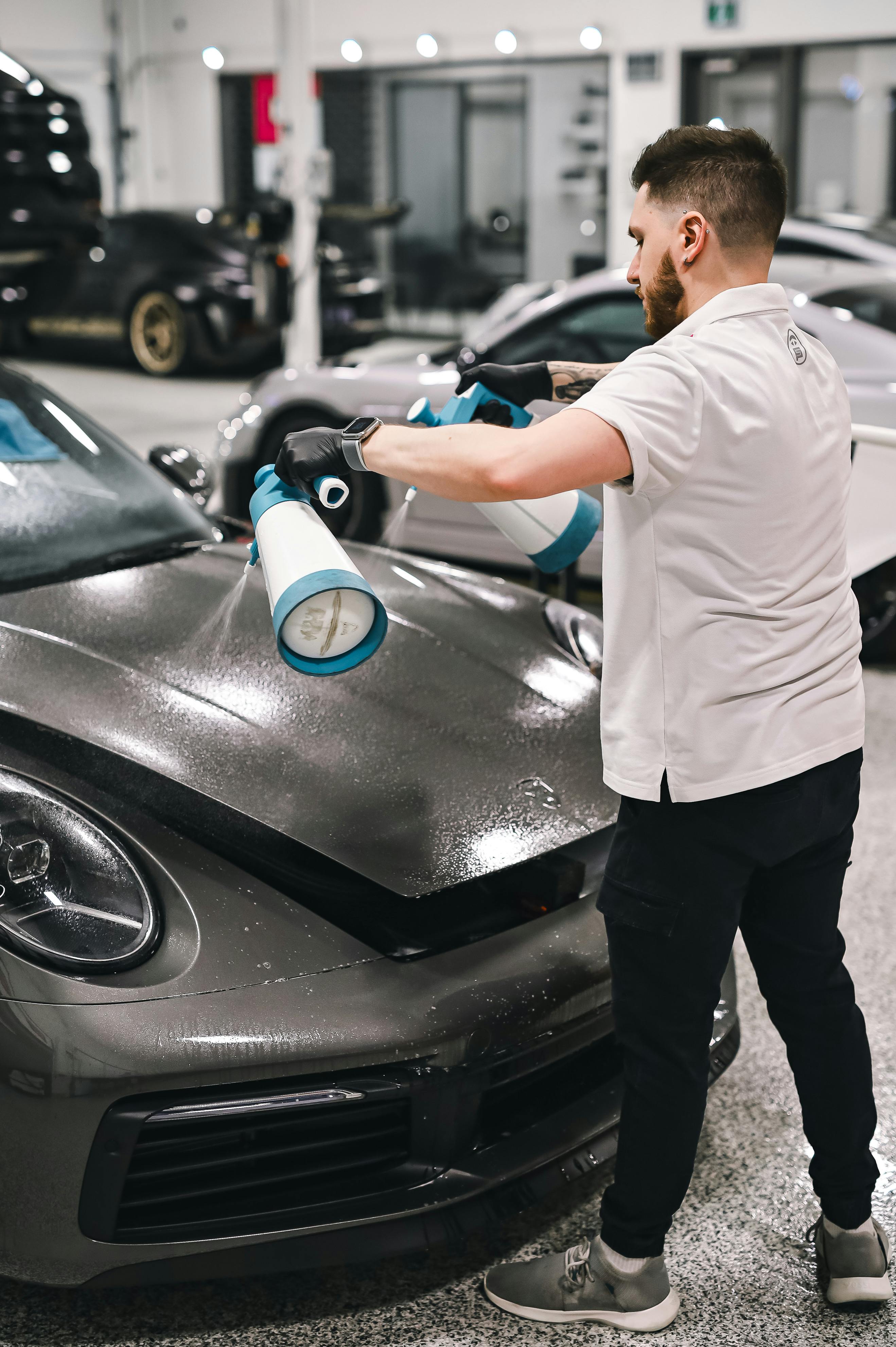 Man Spraying Cleaning Liquid on Sports Car Hood · Free Stock Photo