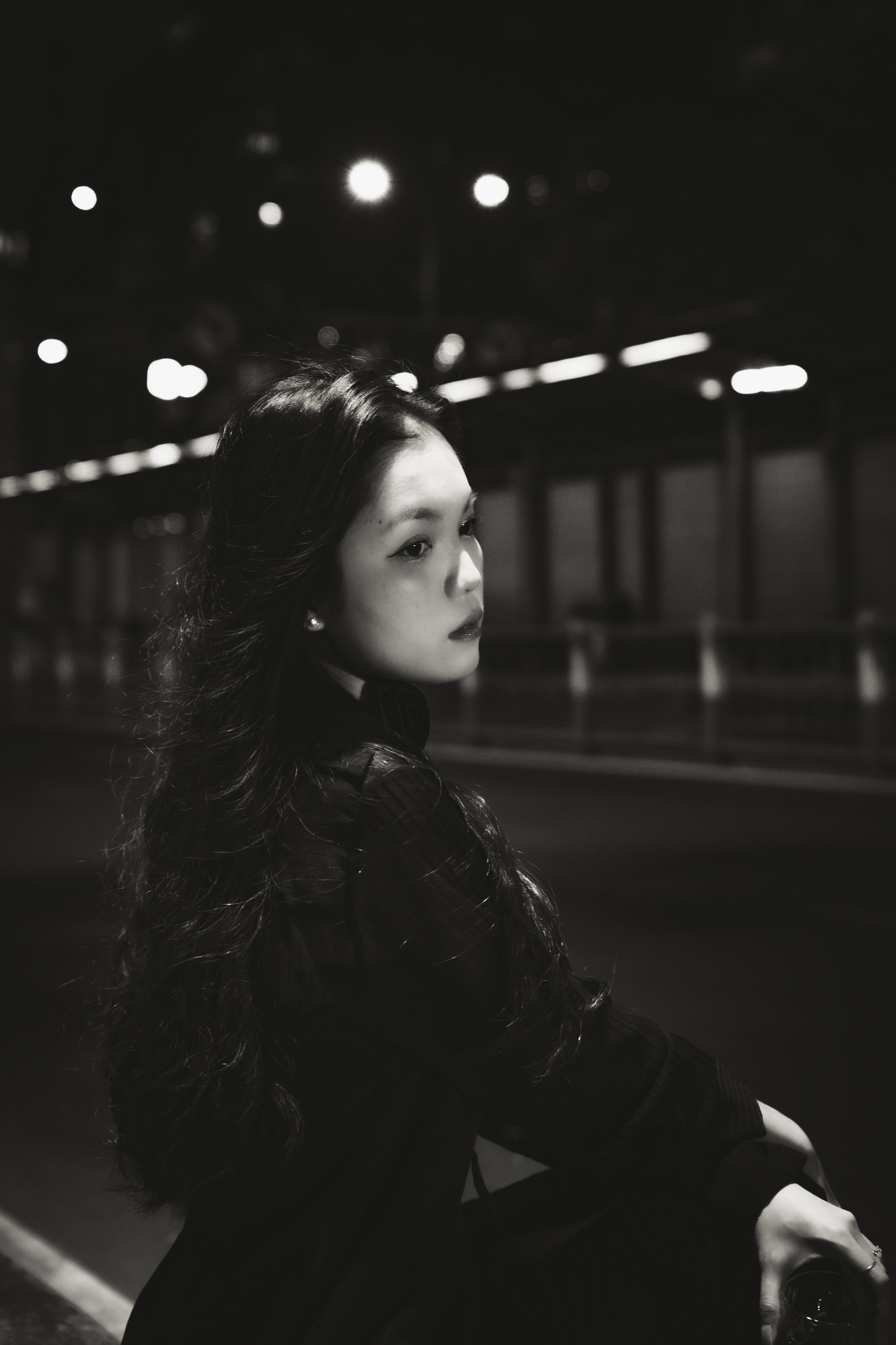 A woman sitting on the street in black and white · Free Stock Photo