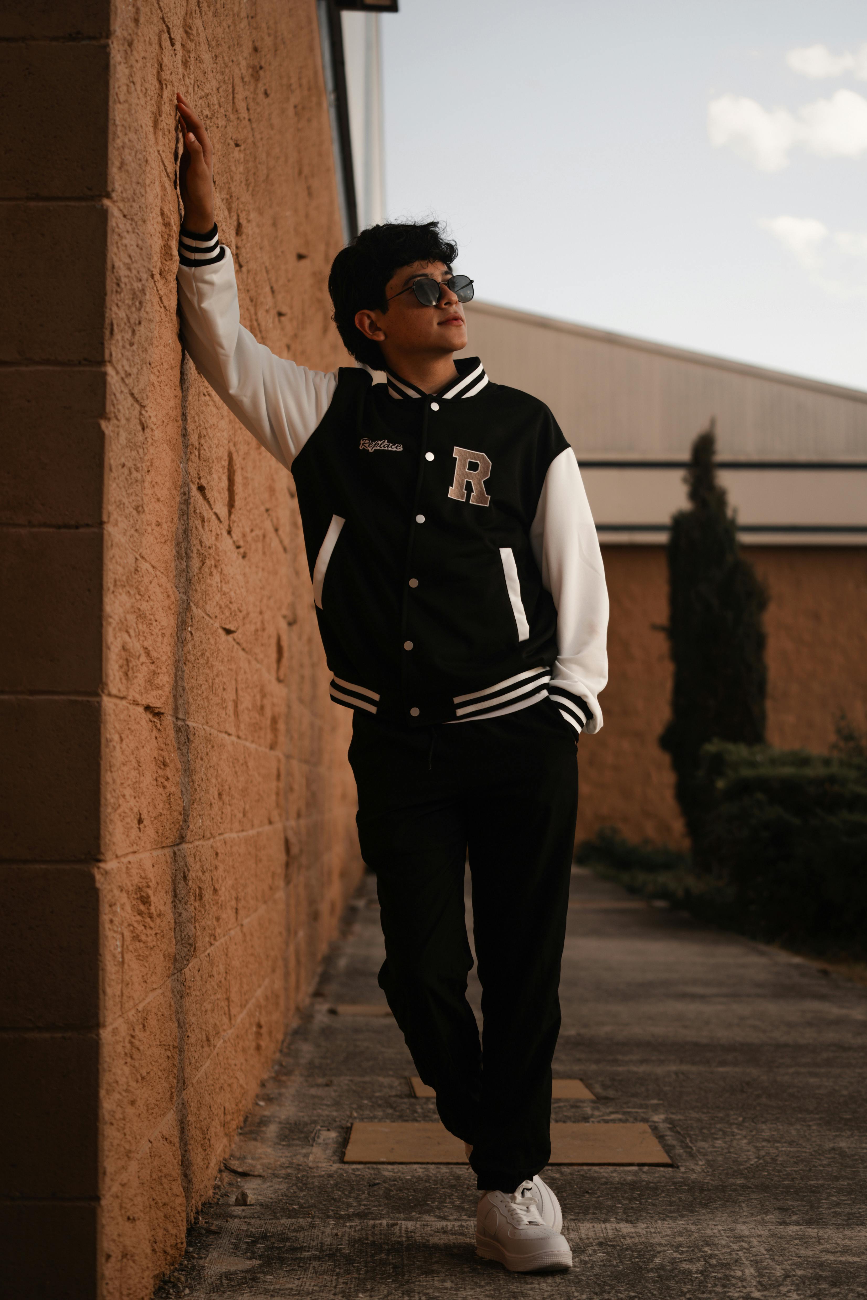 Man Wearing Baseball Jacket on a Street · Free Stock Photo