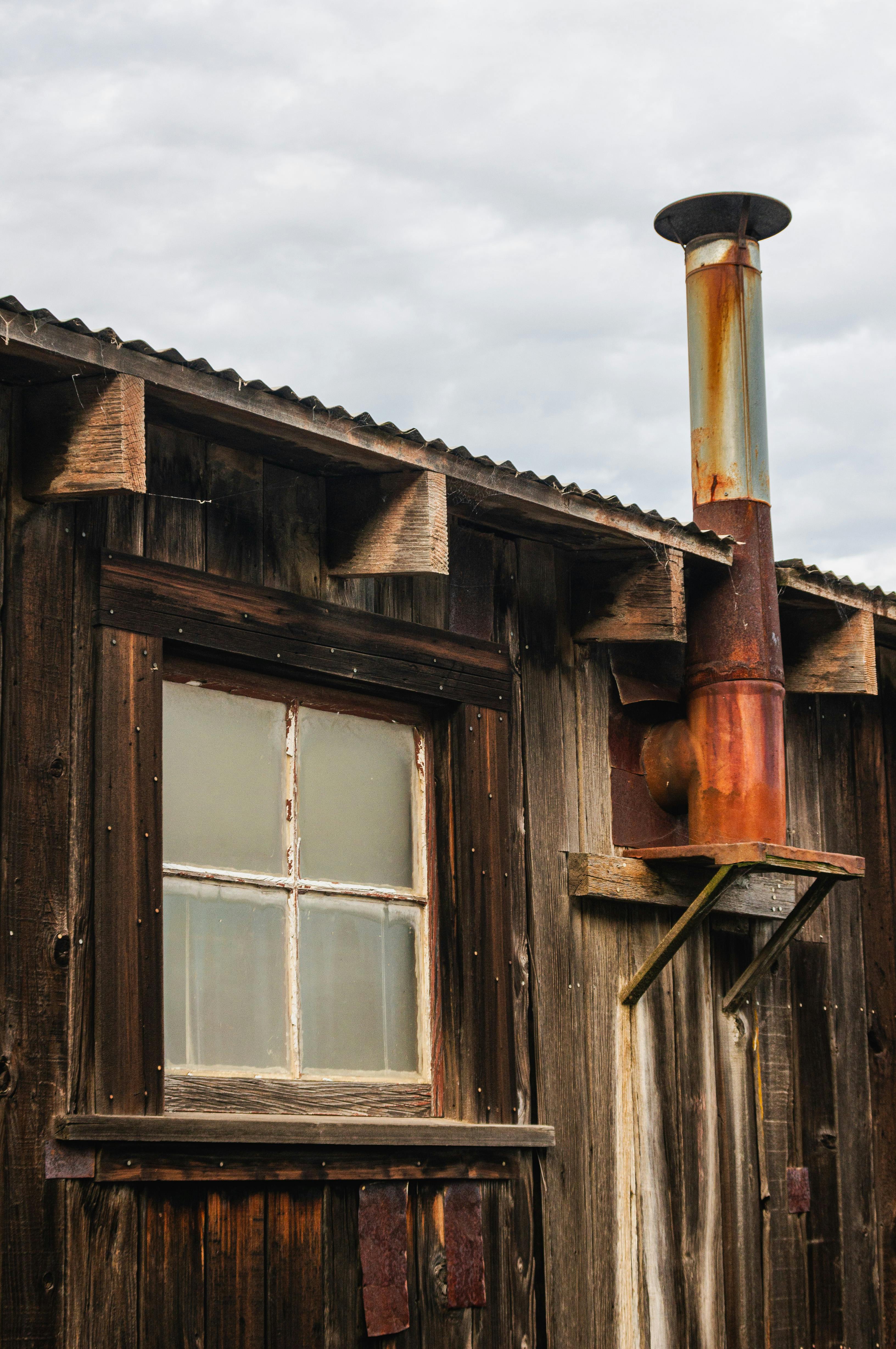 A rusty chimney on the side of a building · Free Stock Photo