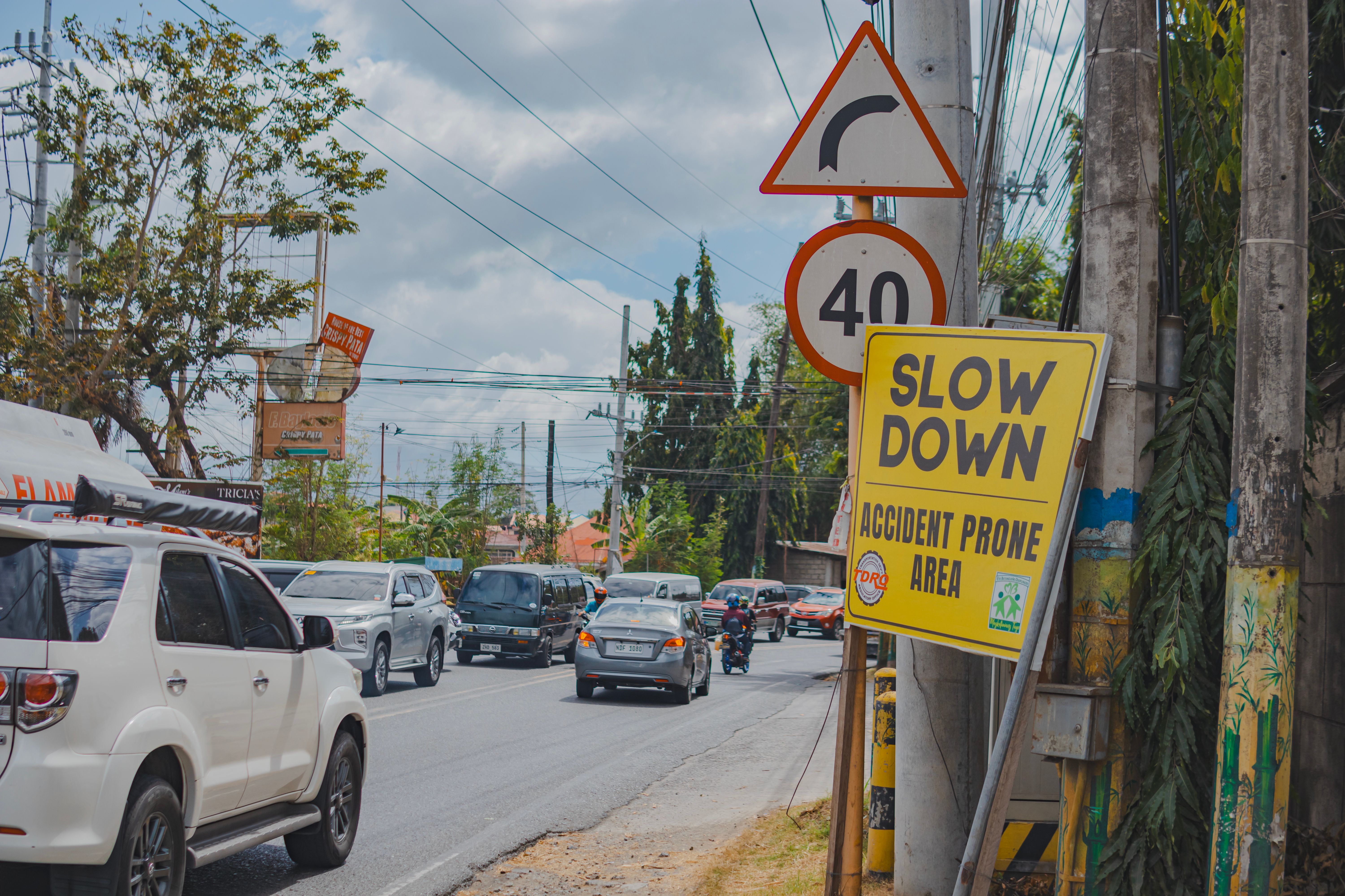 A street with cars and signs that say slow down · Free Stock Photo