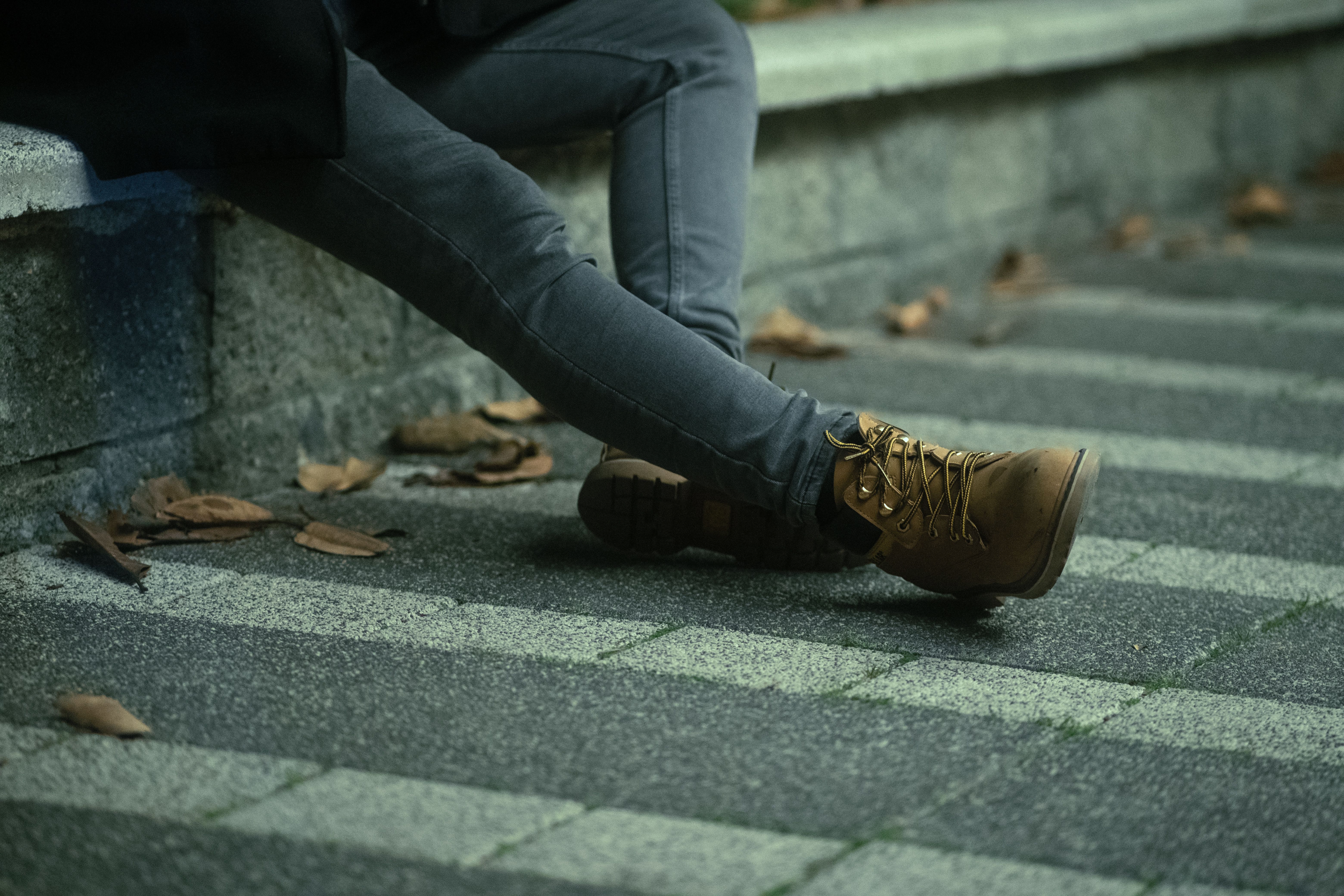 Legs of Man Sitting on Pavement · Free Stock Photo