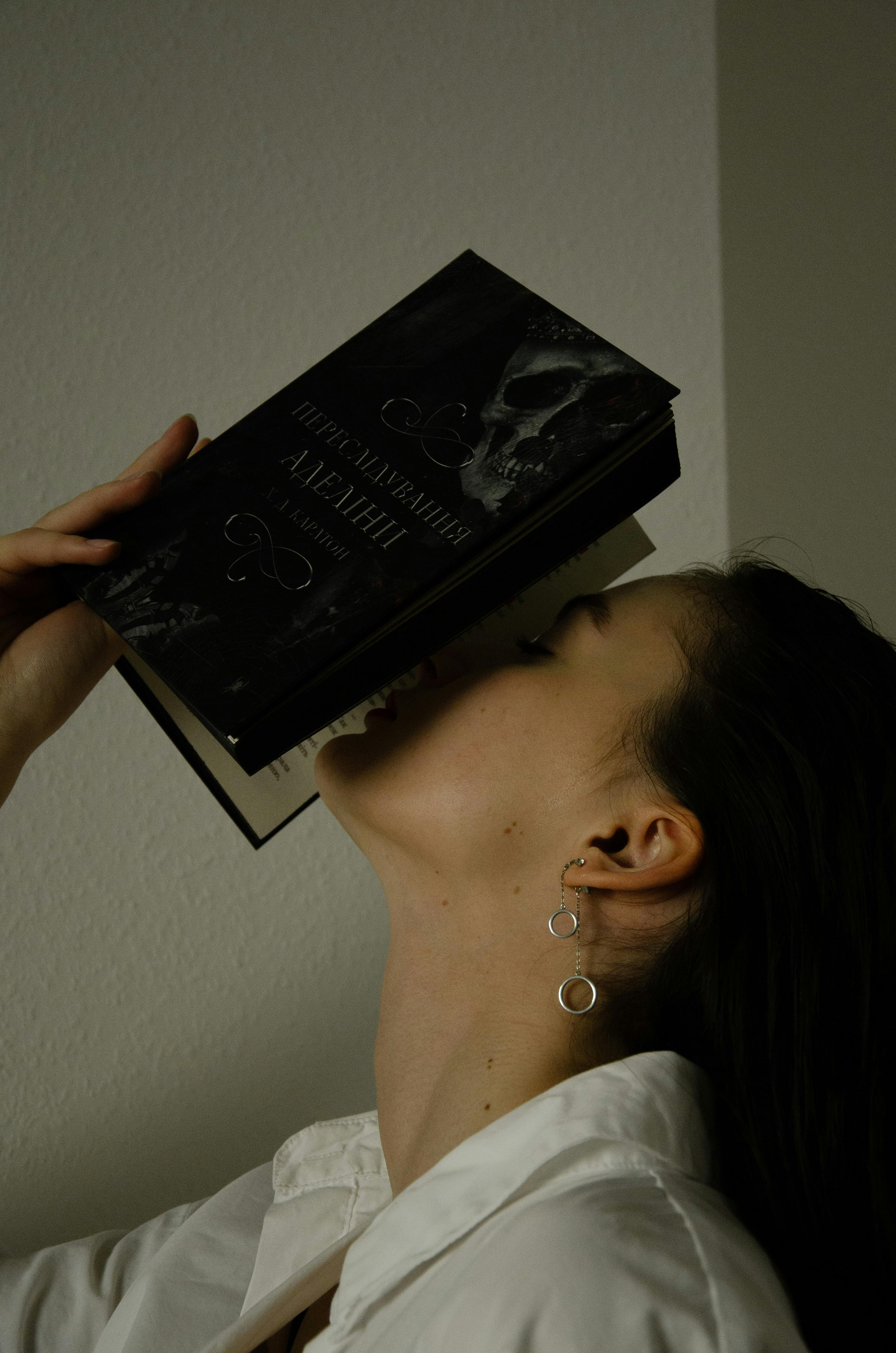 Woman Holding Book over Face · Free Stock Photo