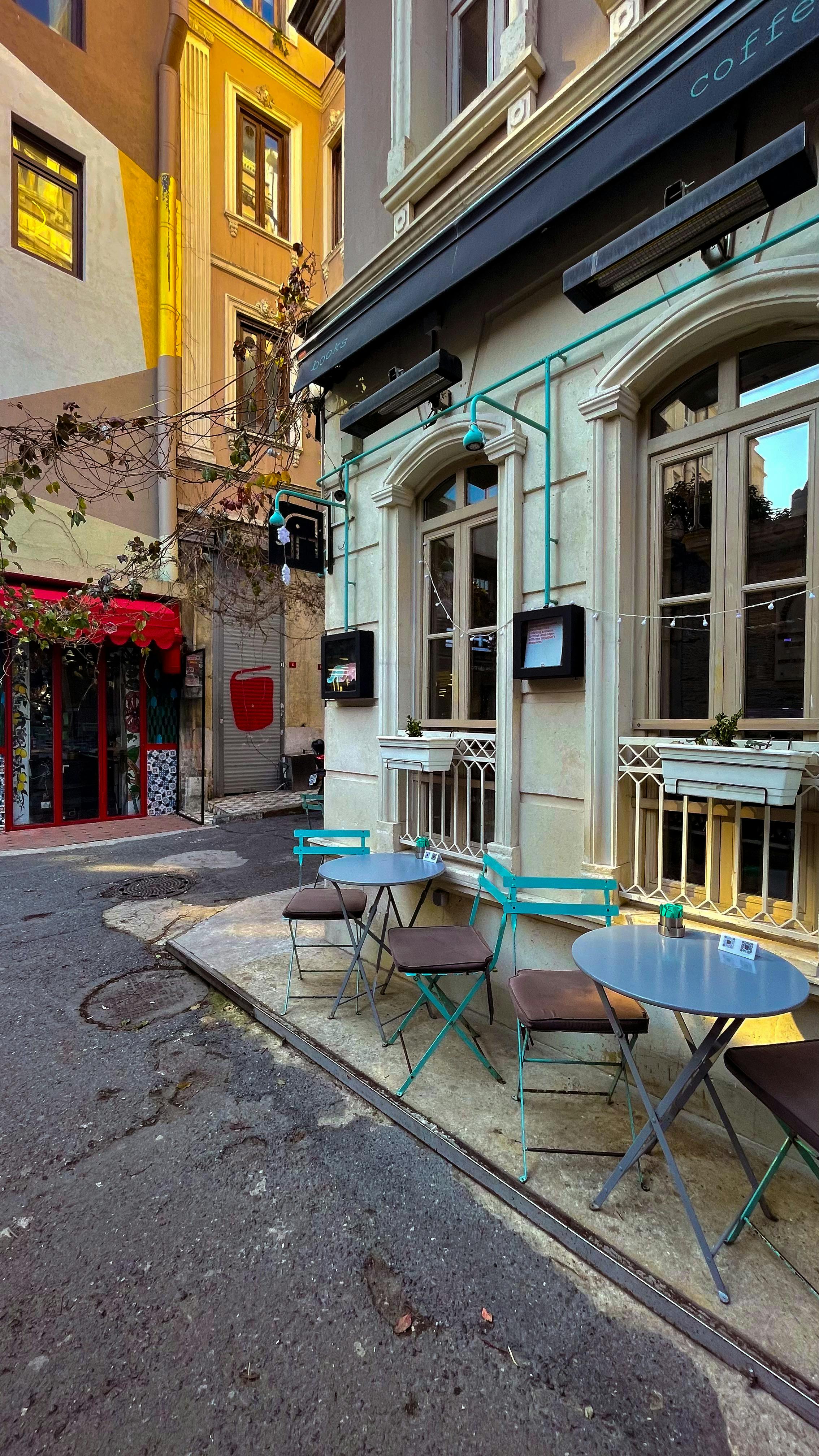 Tables in Front of a Cafe in a Side Street · Free Stock Photo