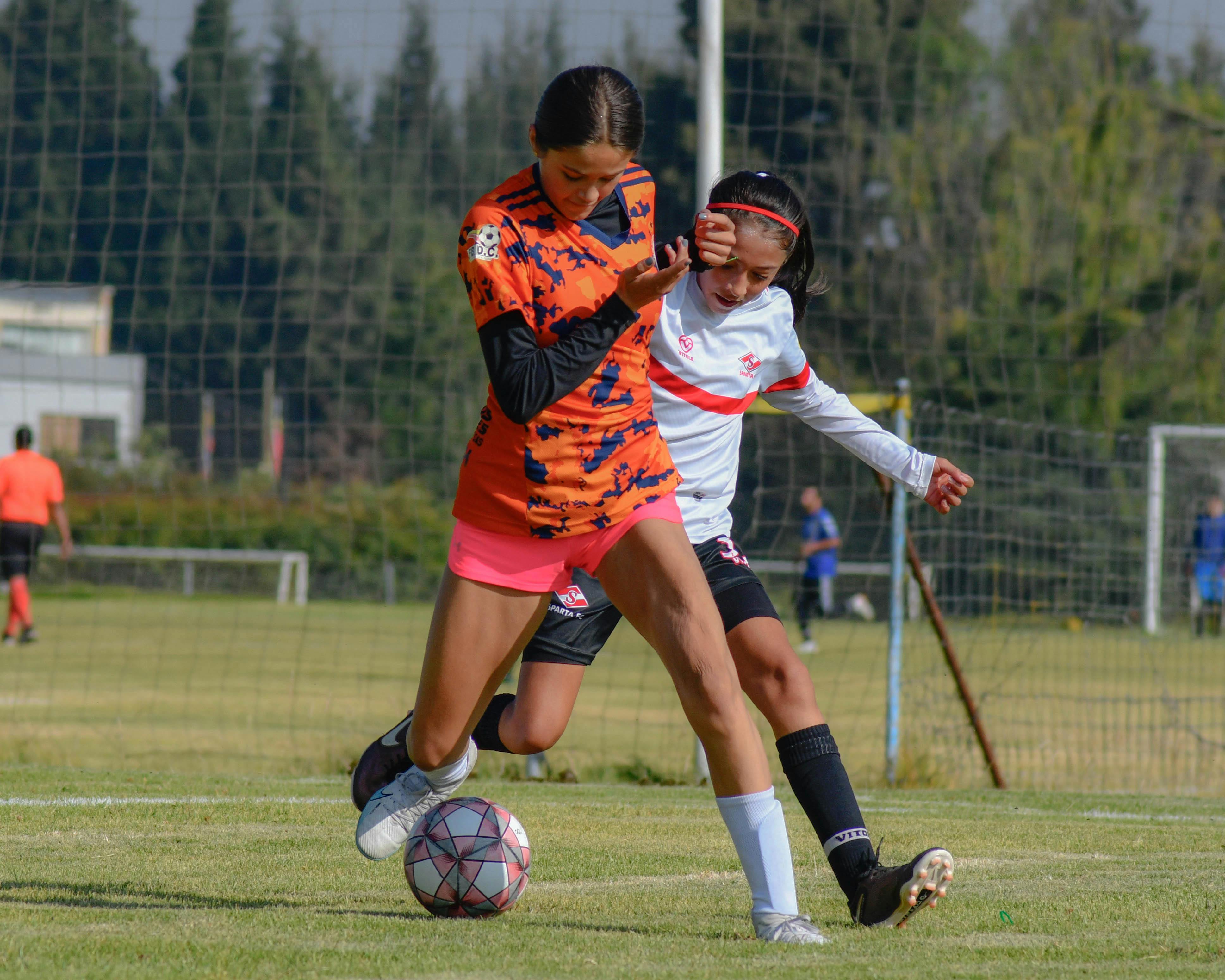 Girls Playing Football on Pitch · Free Stock Photo