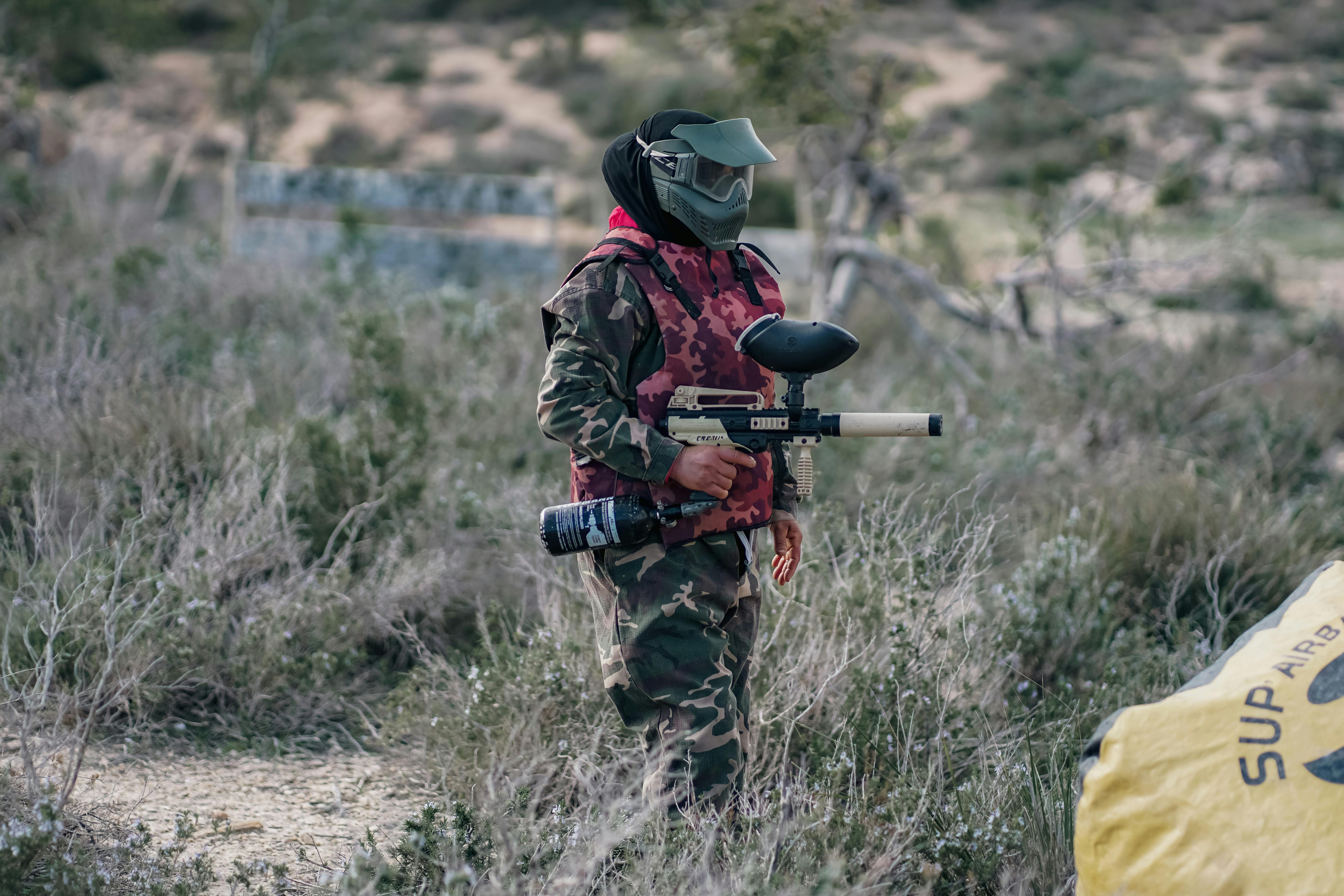 Man Standing with Paintball Rifle · Free Stock Photo