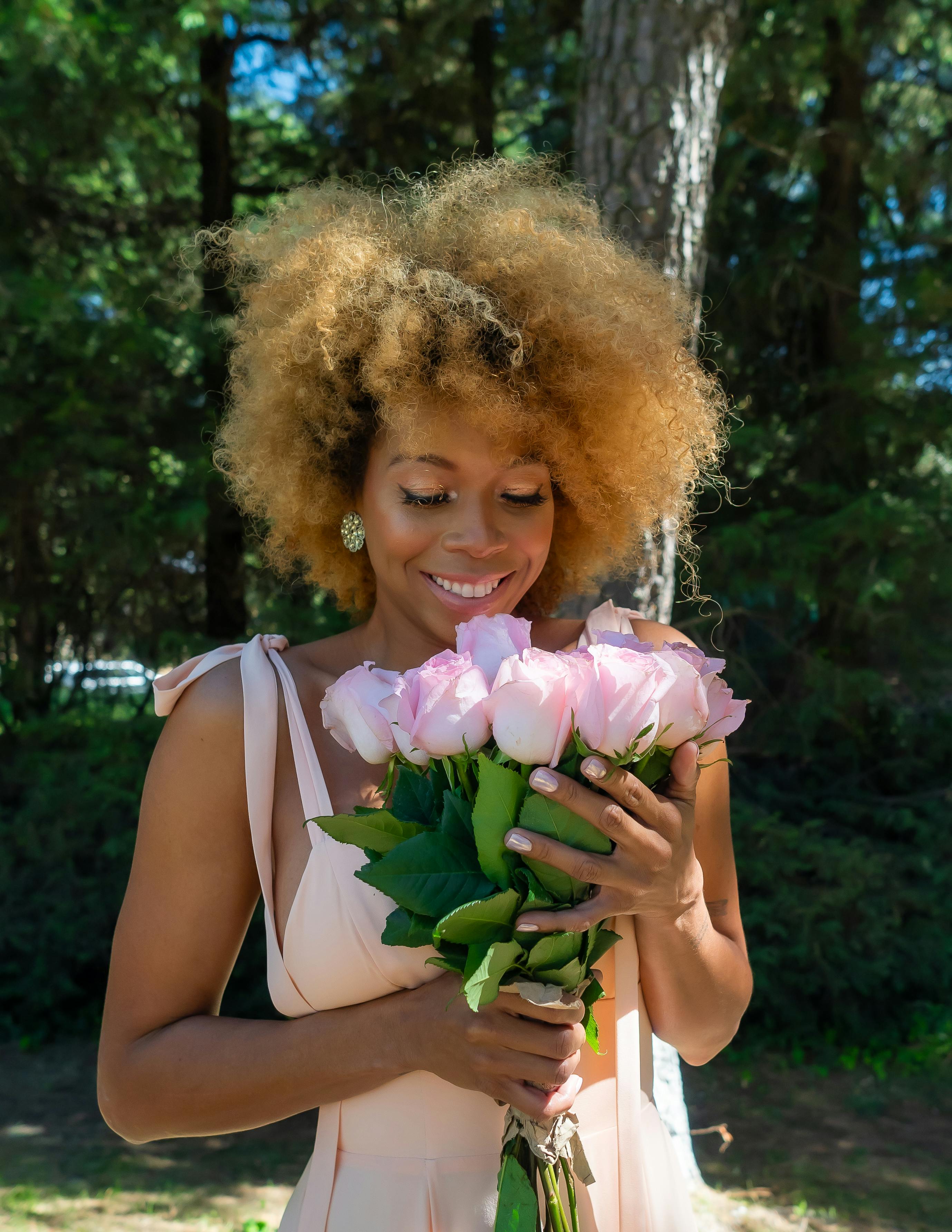 Young Woman Holding a Bouquet of Roses · Free Stock Photo