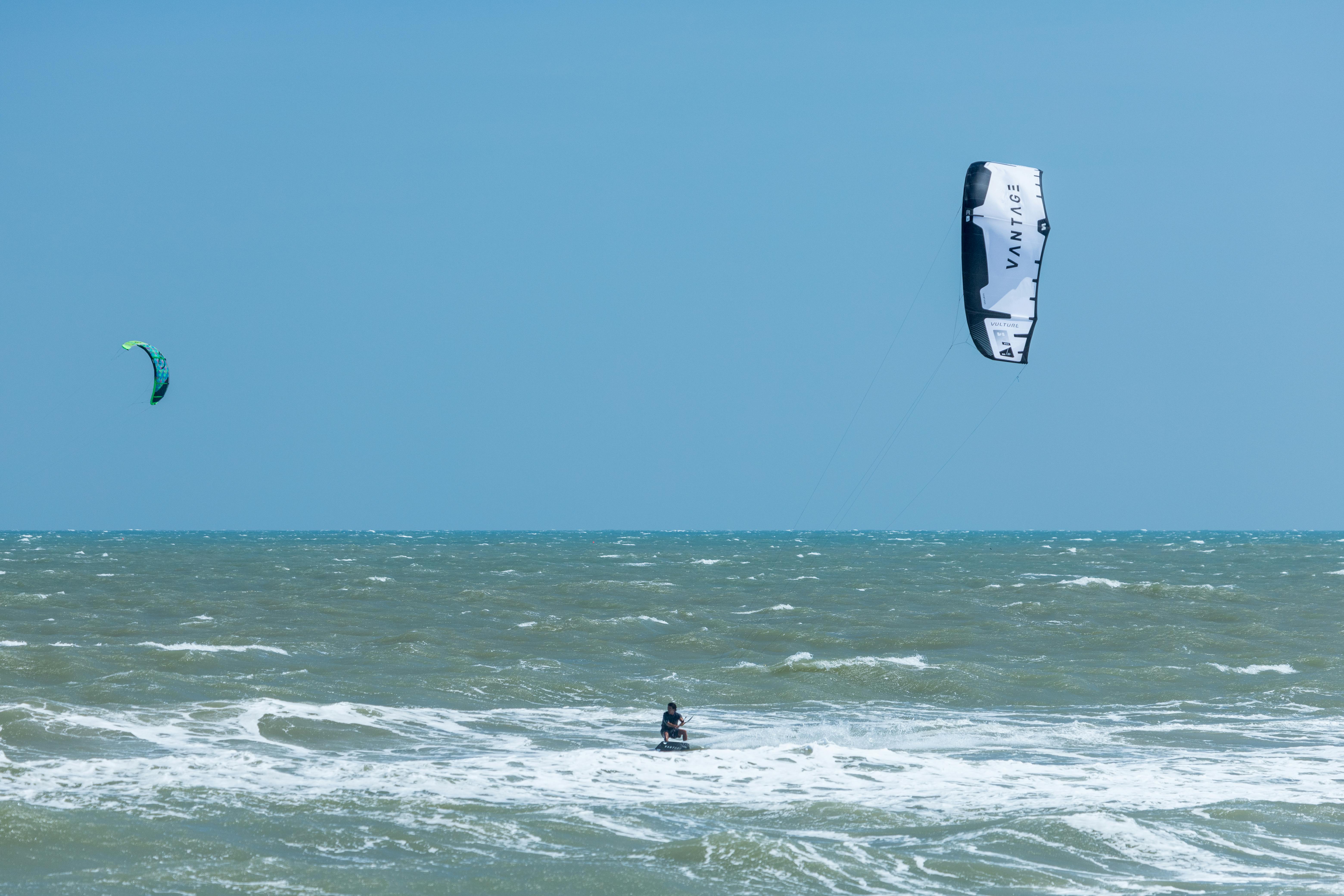A kite surfer in the ocean with a kite · Free Stock Photo