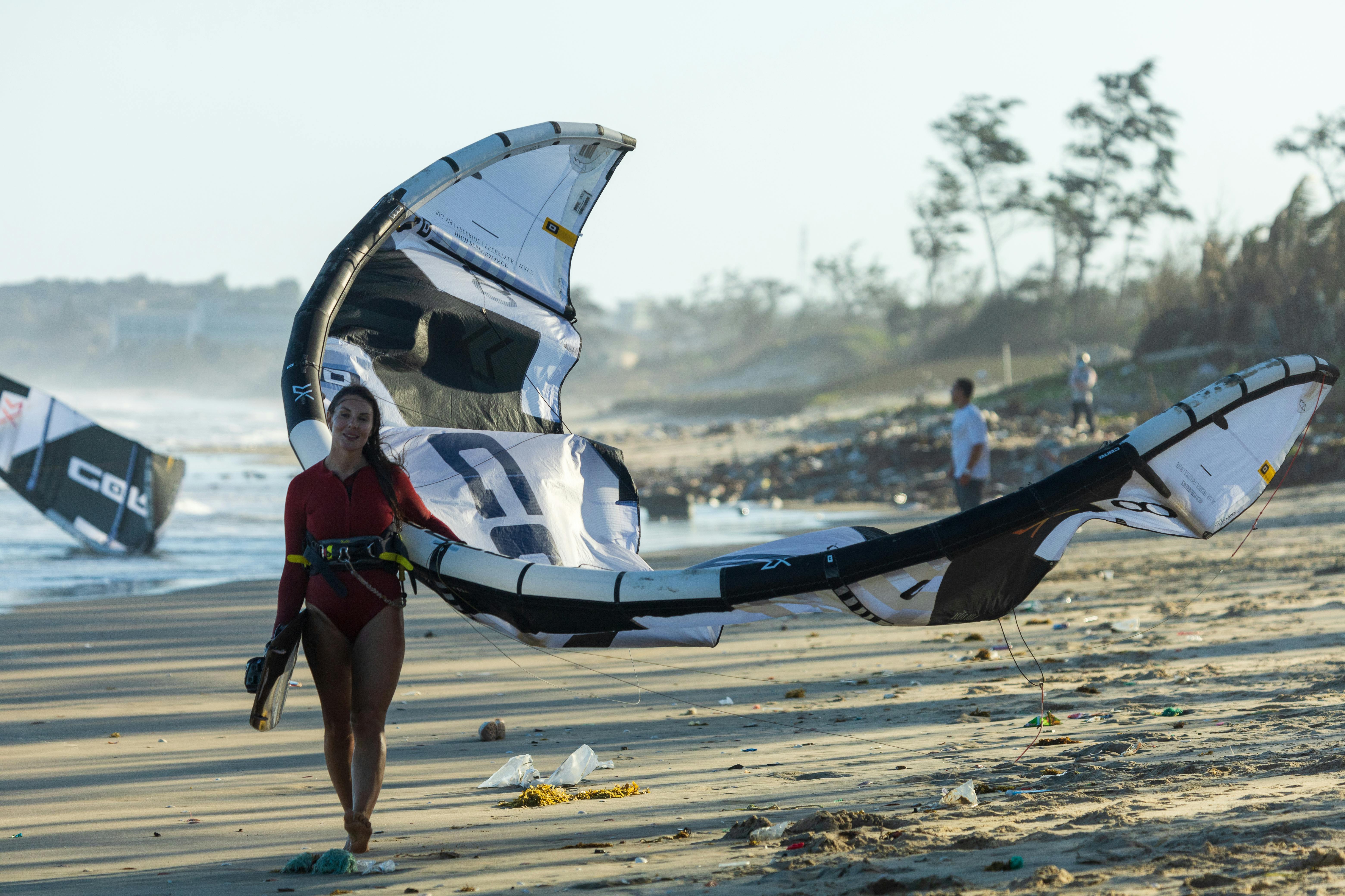 Woman Carrying Kite for Surfing on Beach · Free Stock Photo
