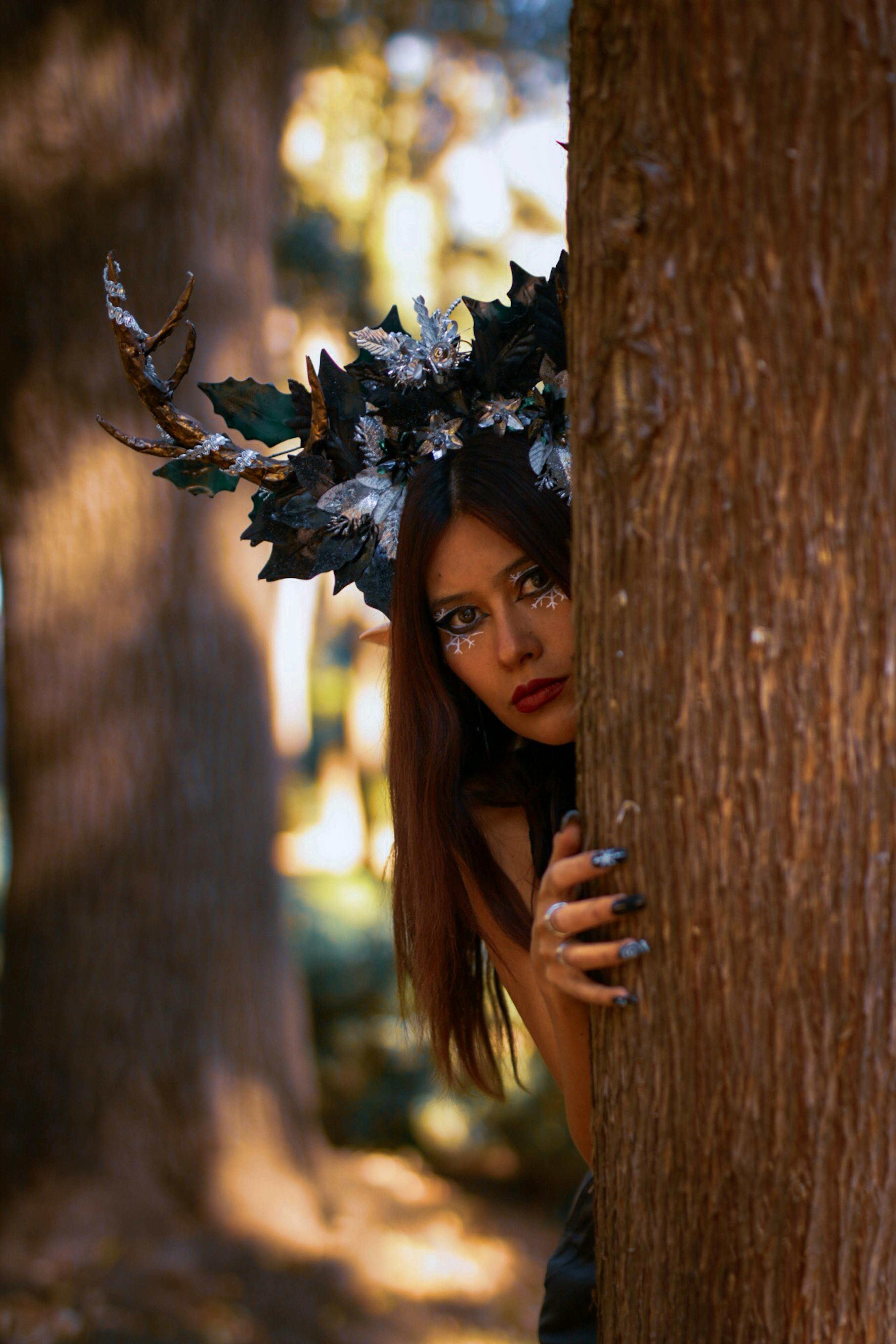 Brunette Woman Peeking Behind Tree · Free Stock Photo