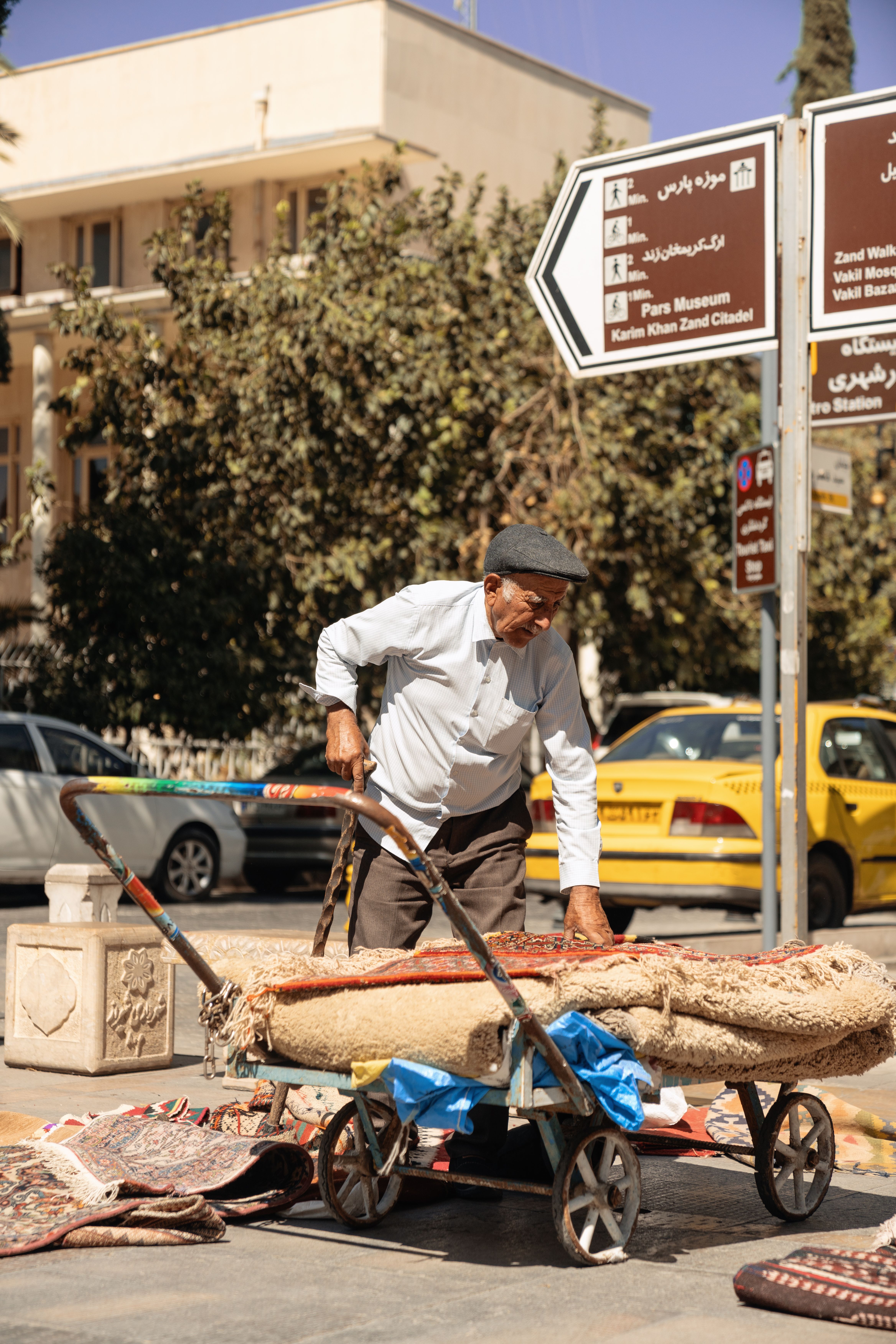 Elderly Man with Carpets on a Cart · Free Stock Photo