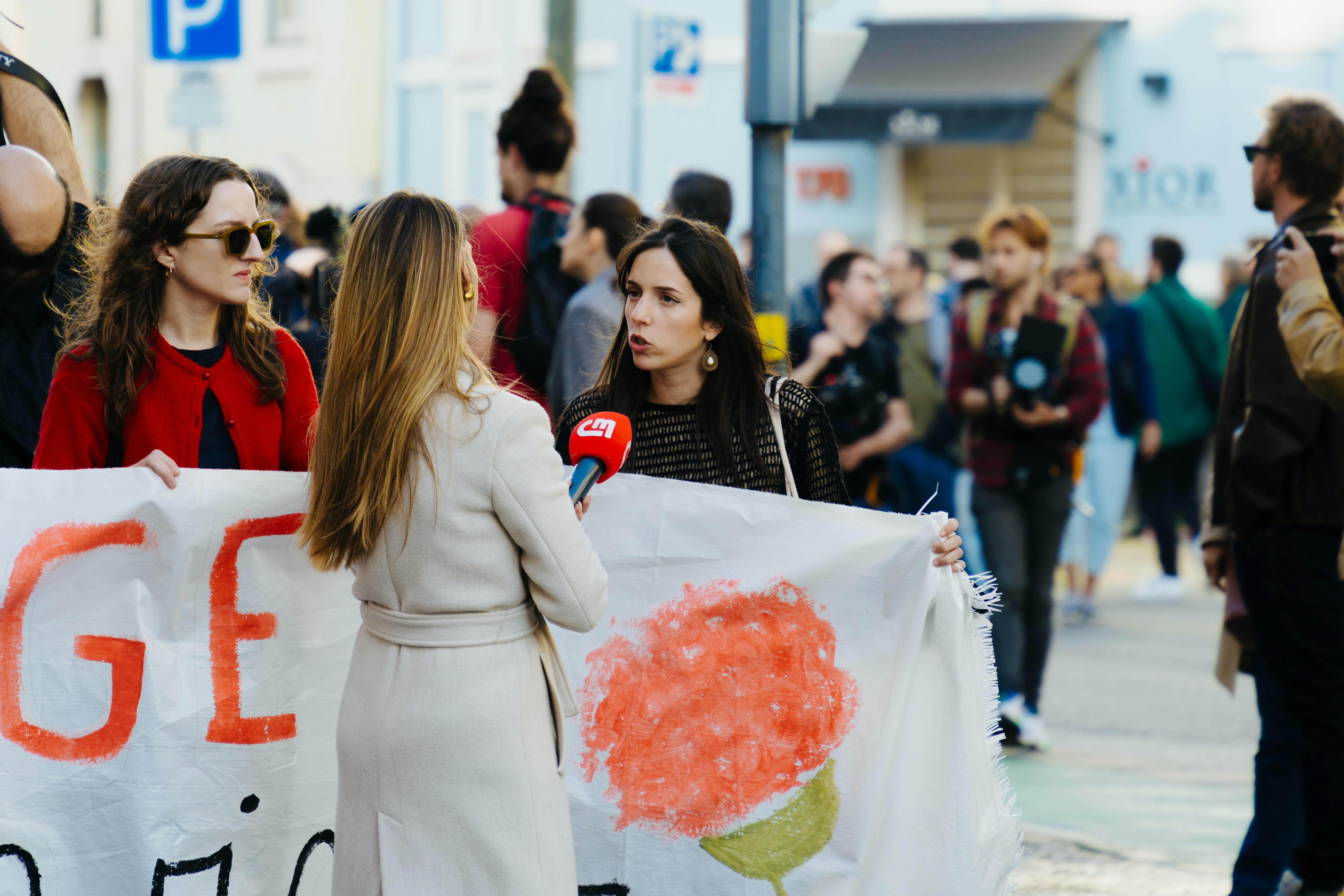 Women Holding a Banner Getting Interviewed · Free Stock Photo