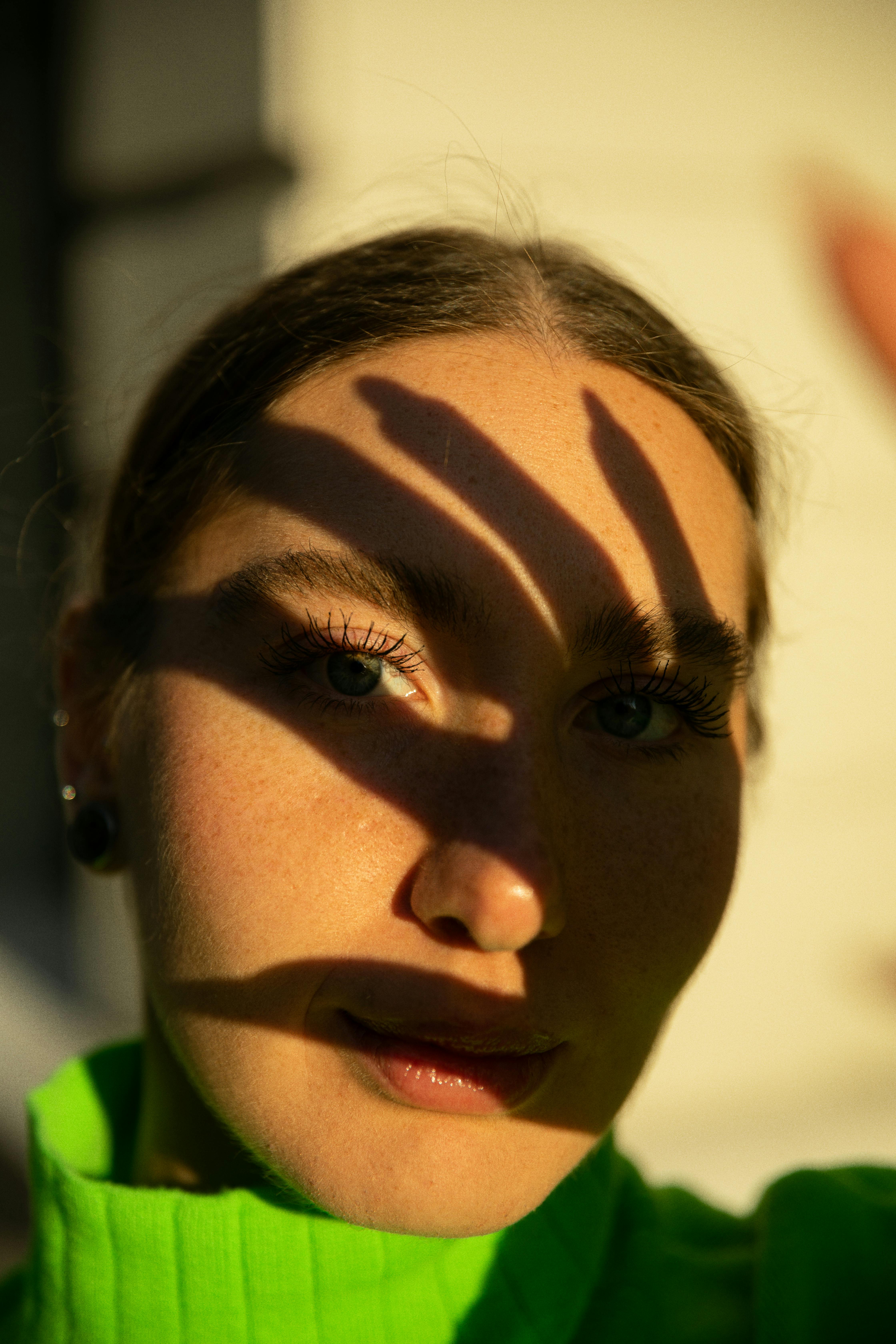 Hand Shadow on Sunlit Woman Face · Free Stock Photo