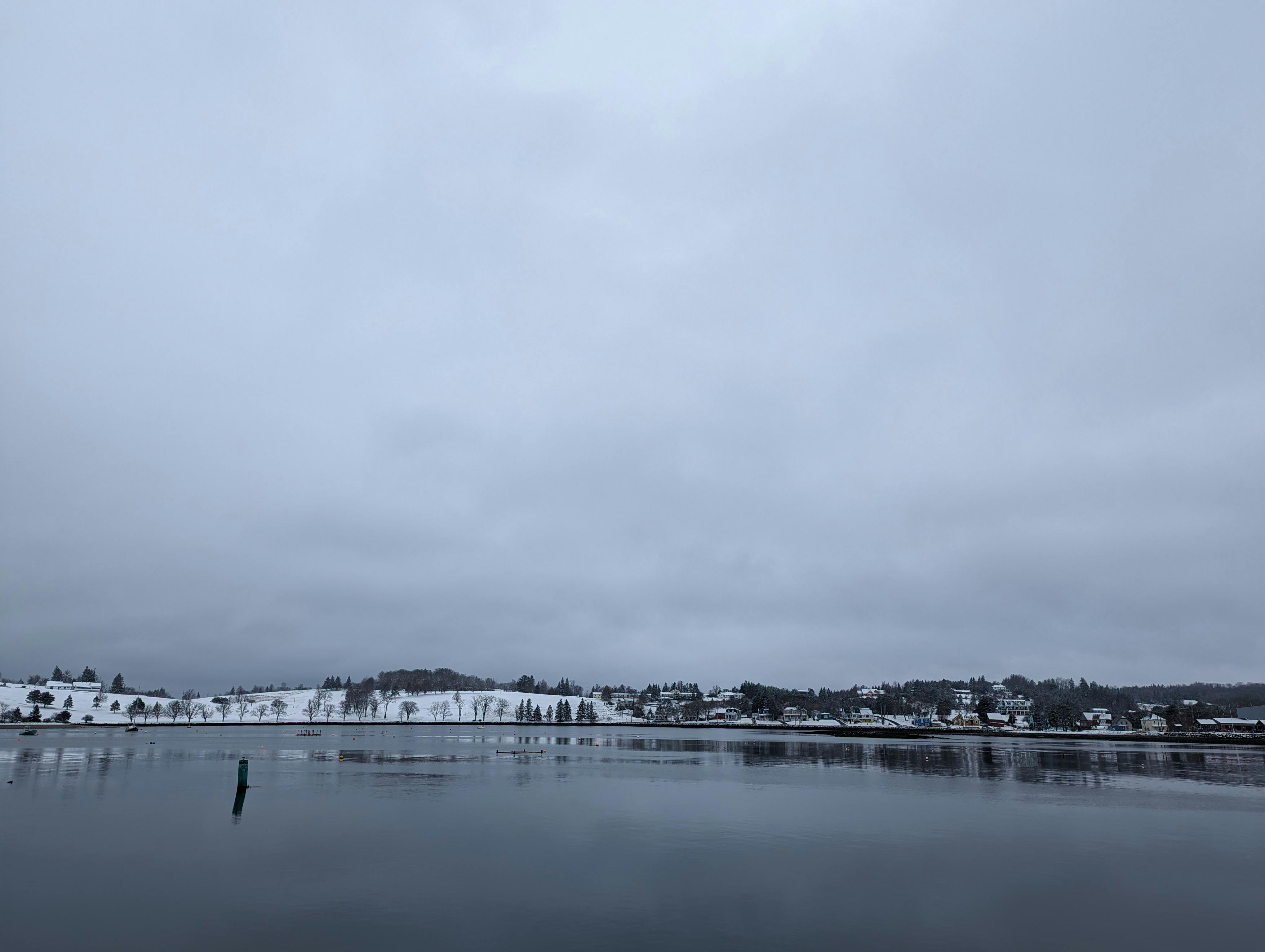 A body of water with snow on the ground · Free Stock Photo