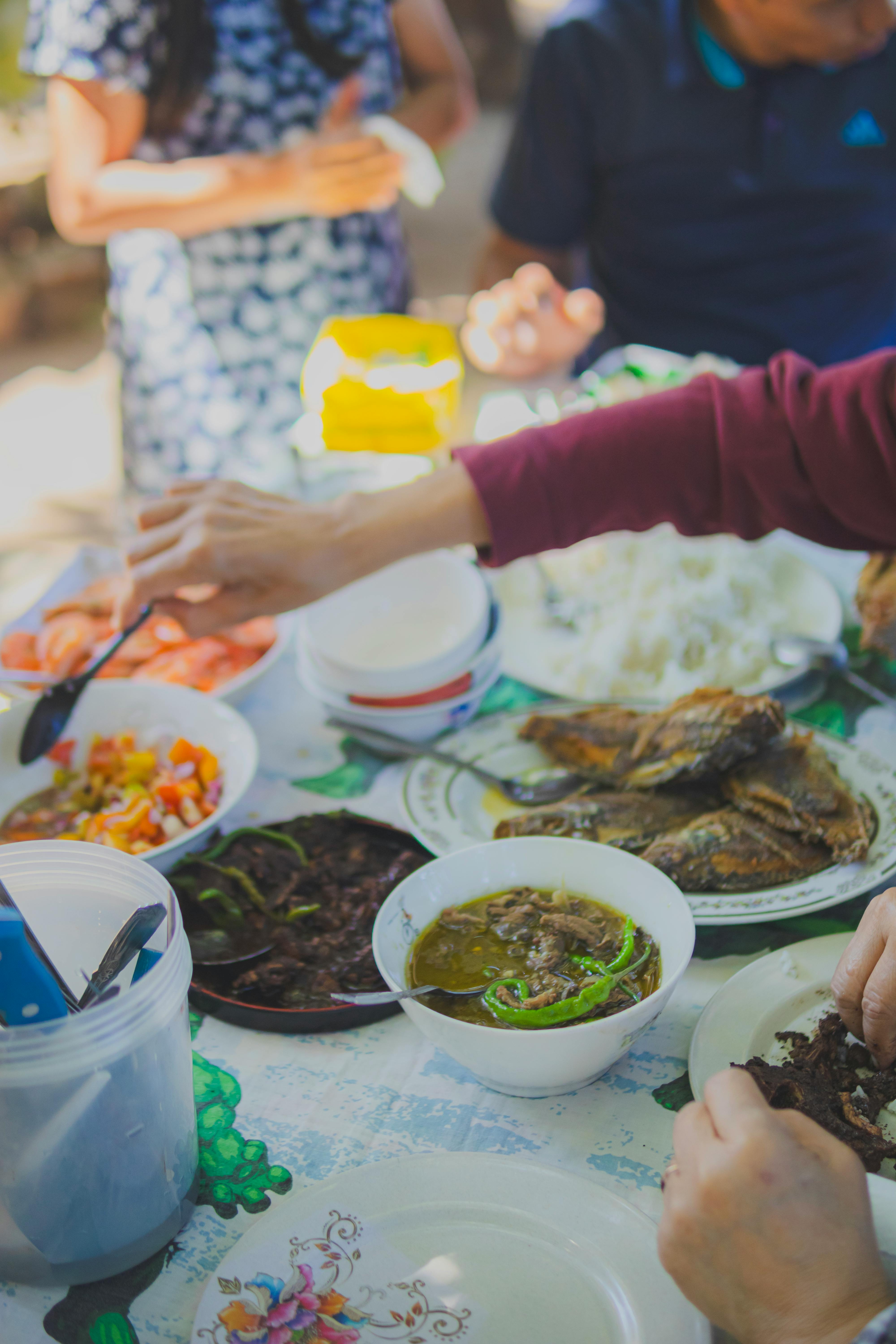 A group of people eating food at a table · Free Stock Photo