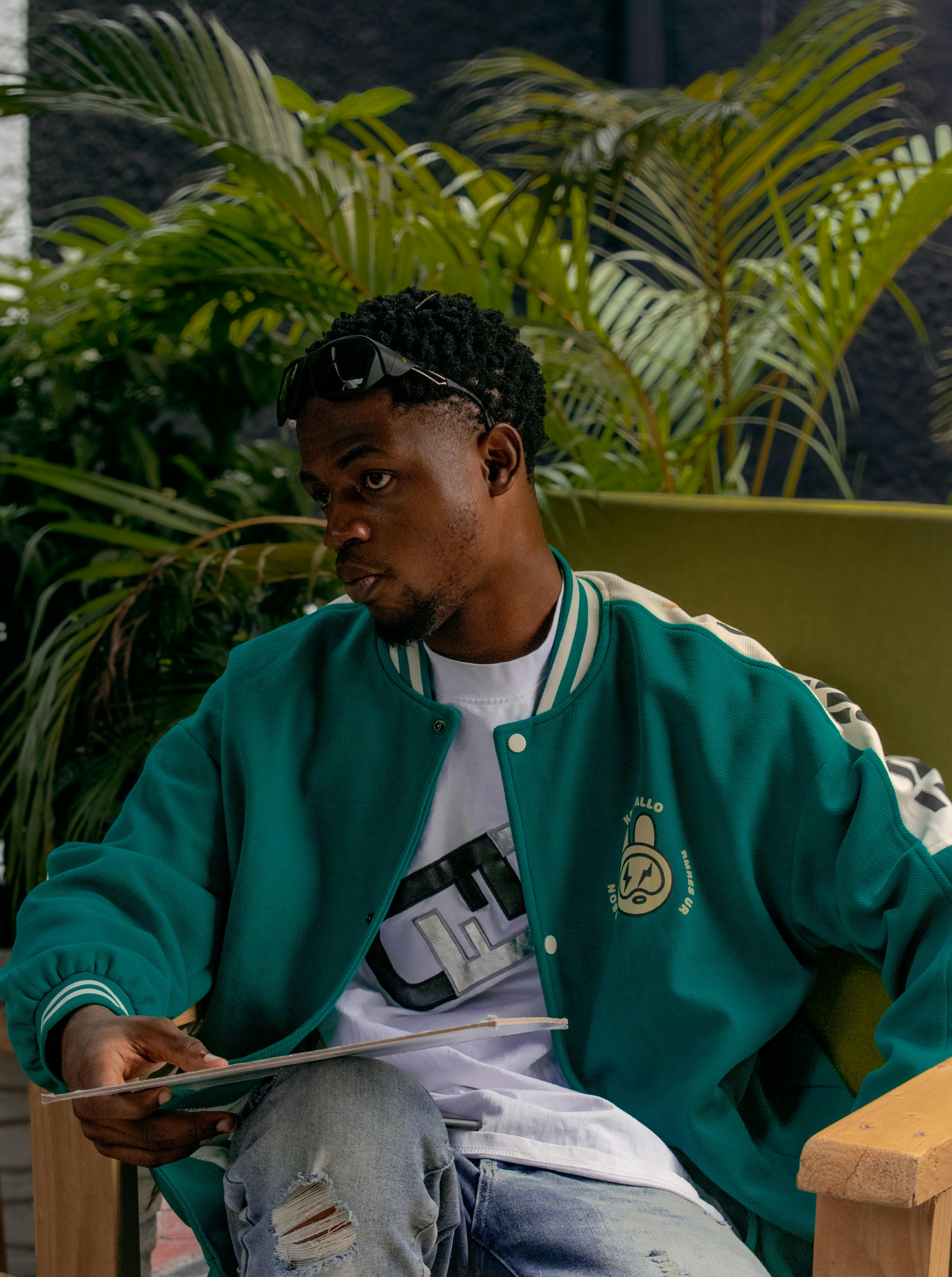 Man Sitting in Green Jacket · Free Stock Photo