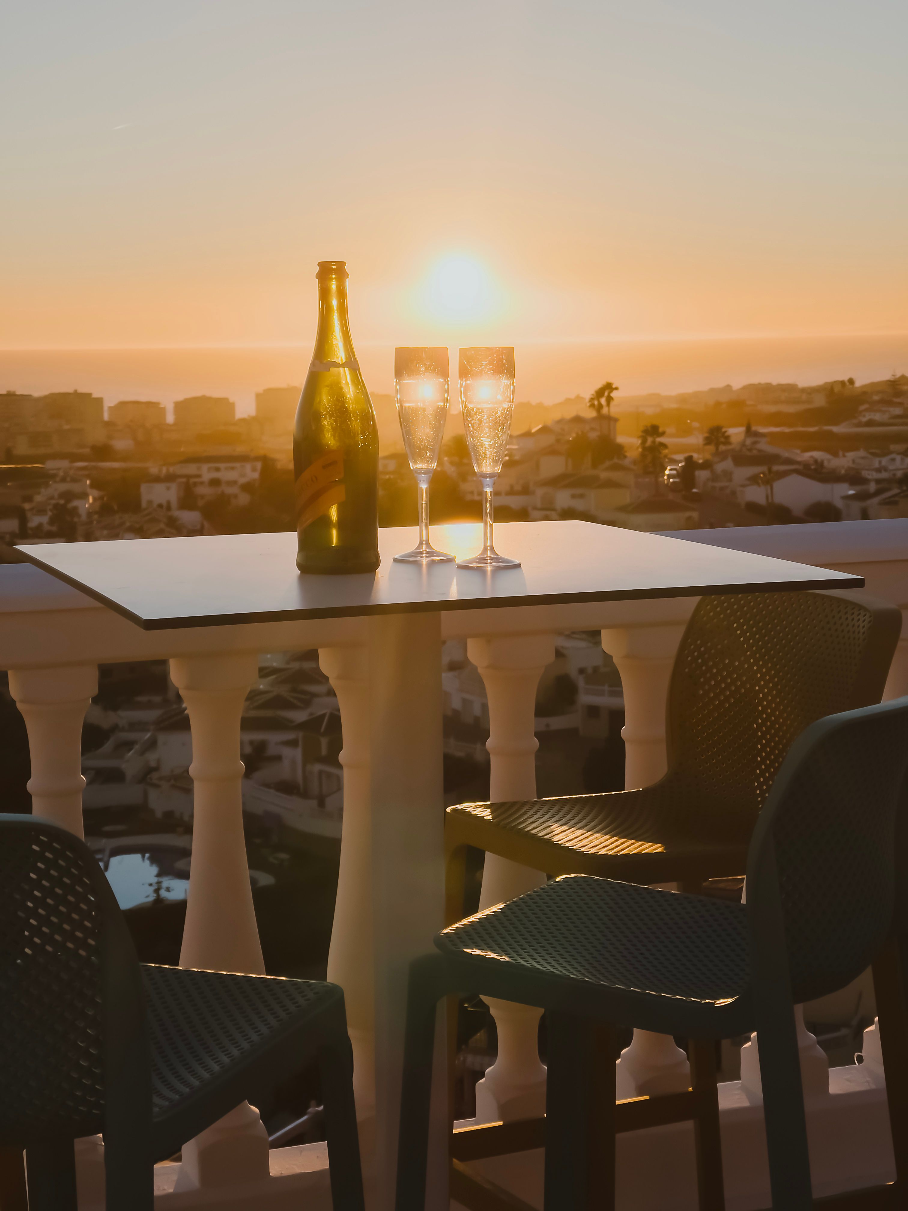 Bottle and Glasses of Champagne on Terrace at Sunset · Free Stock Photo
