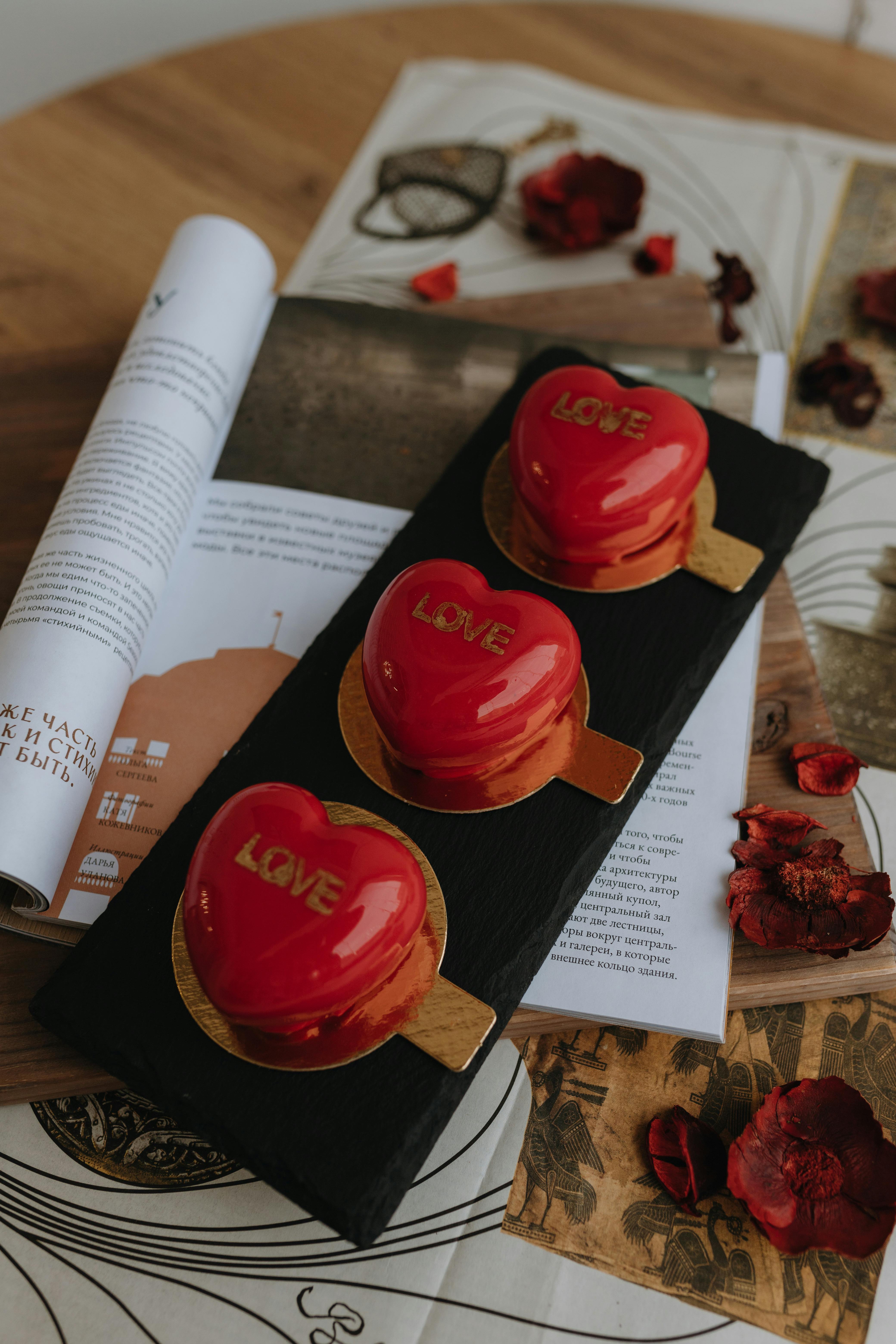 Close-up of Red Pralines Lying on a Magazine · Free Stock Photo