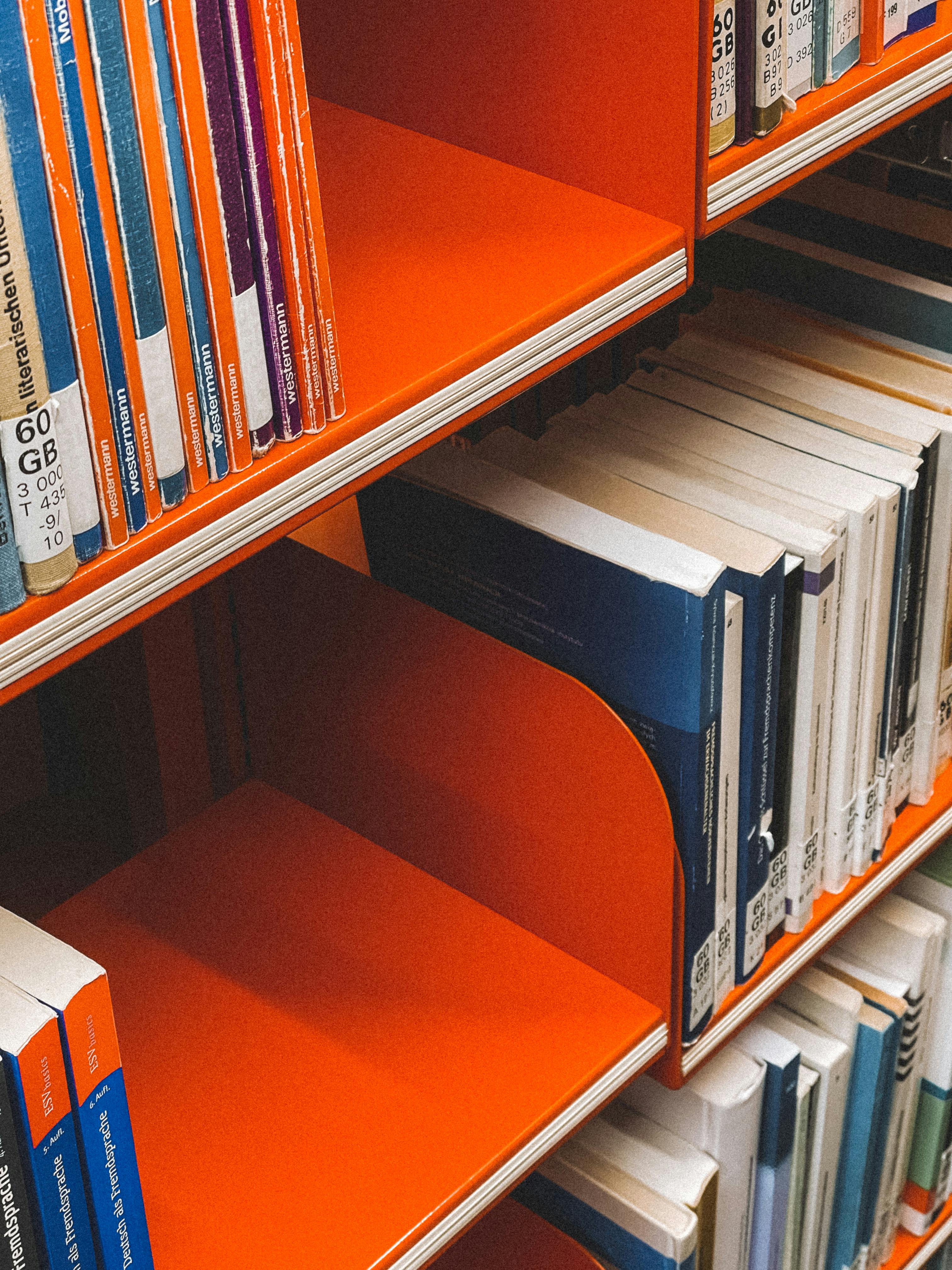 Orange shelves in a library with books on them · Free Stock Photo