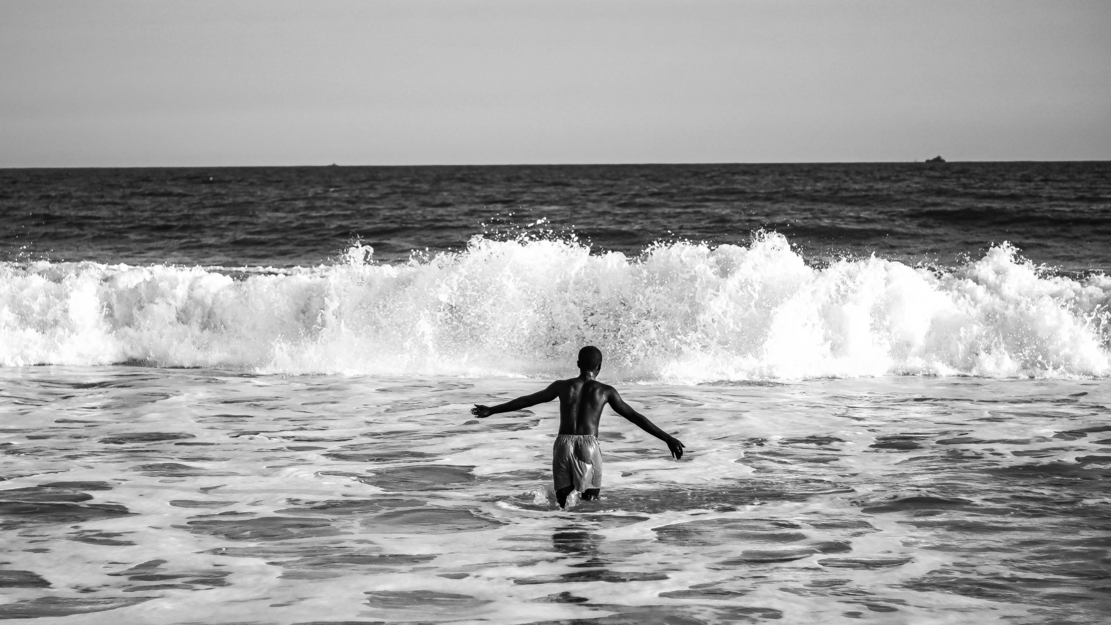 Back View of a Man Standing in Front of a Big Wave · Free Stock Photo