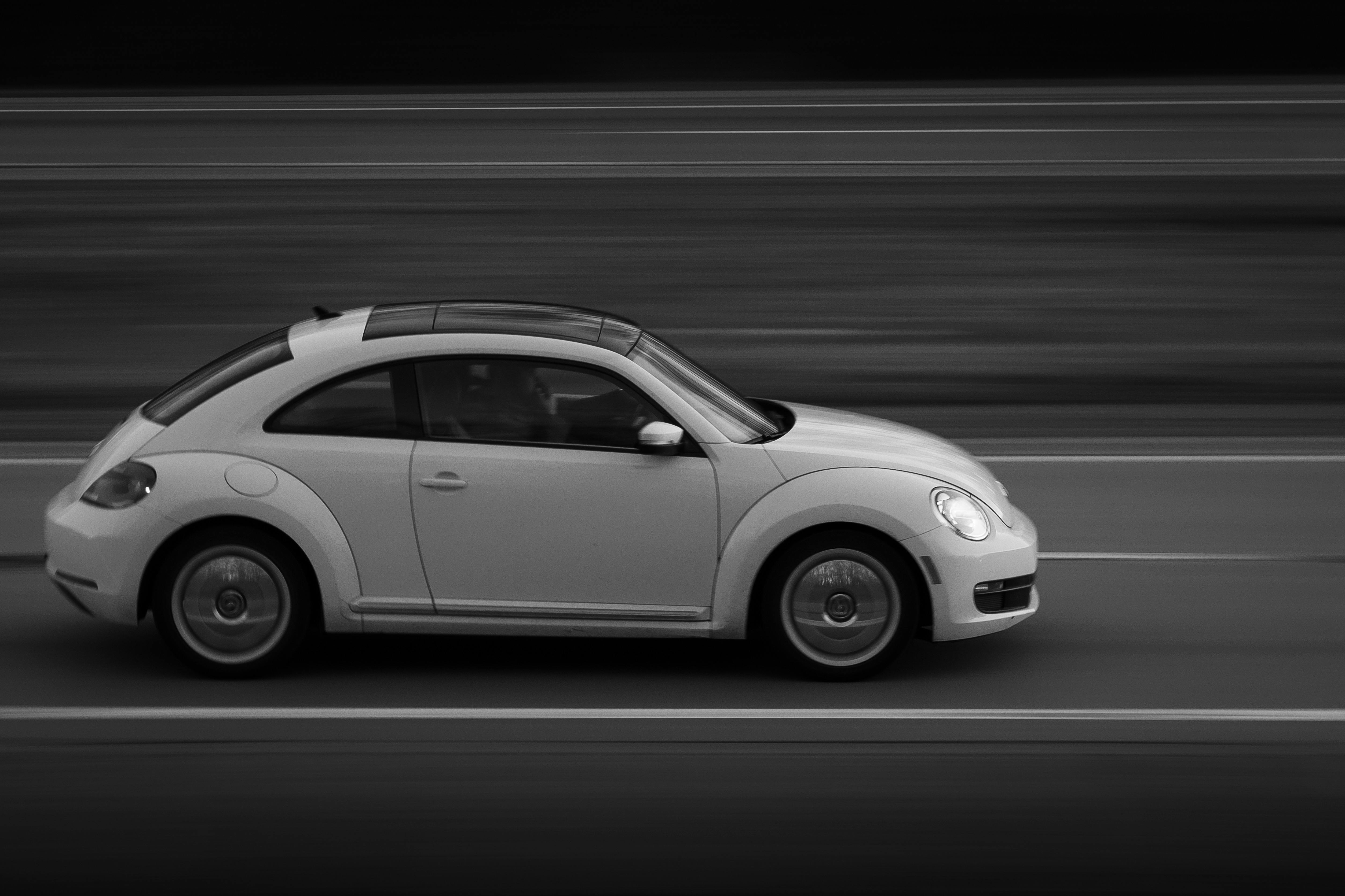 Volkswagen New Beetle Speeding Down the Road · Free Stock Photo