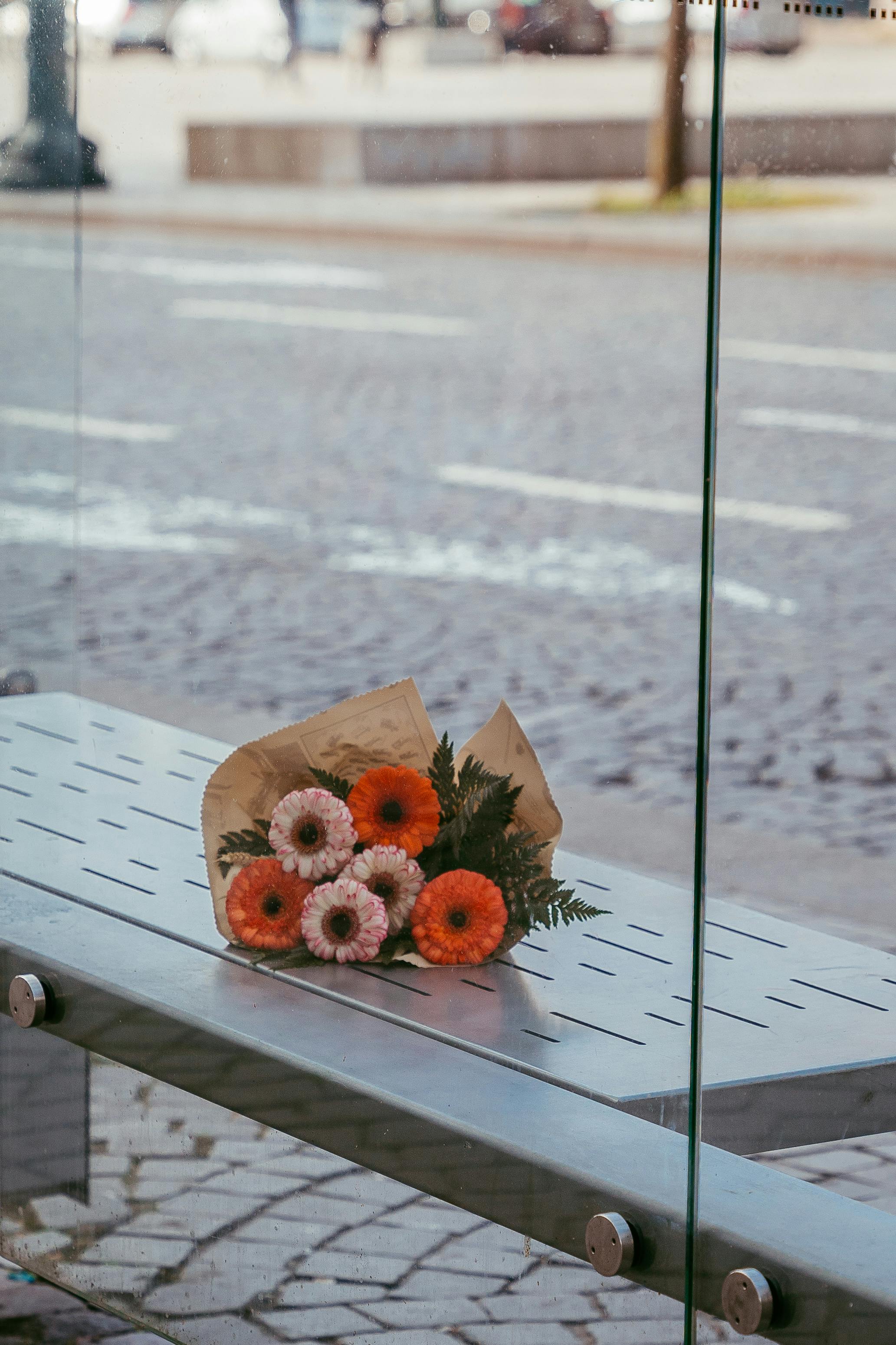 Bouquet of Flowers Lying on a Bench at a Bus Stop · Free Stock Photo