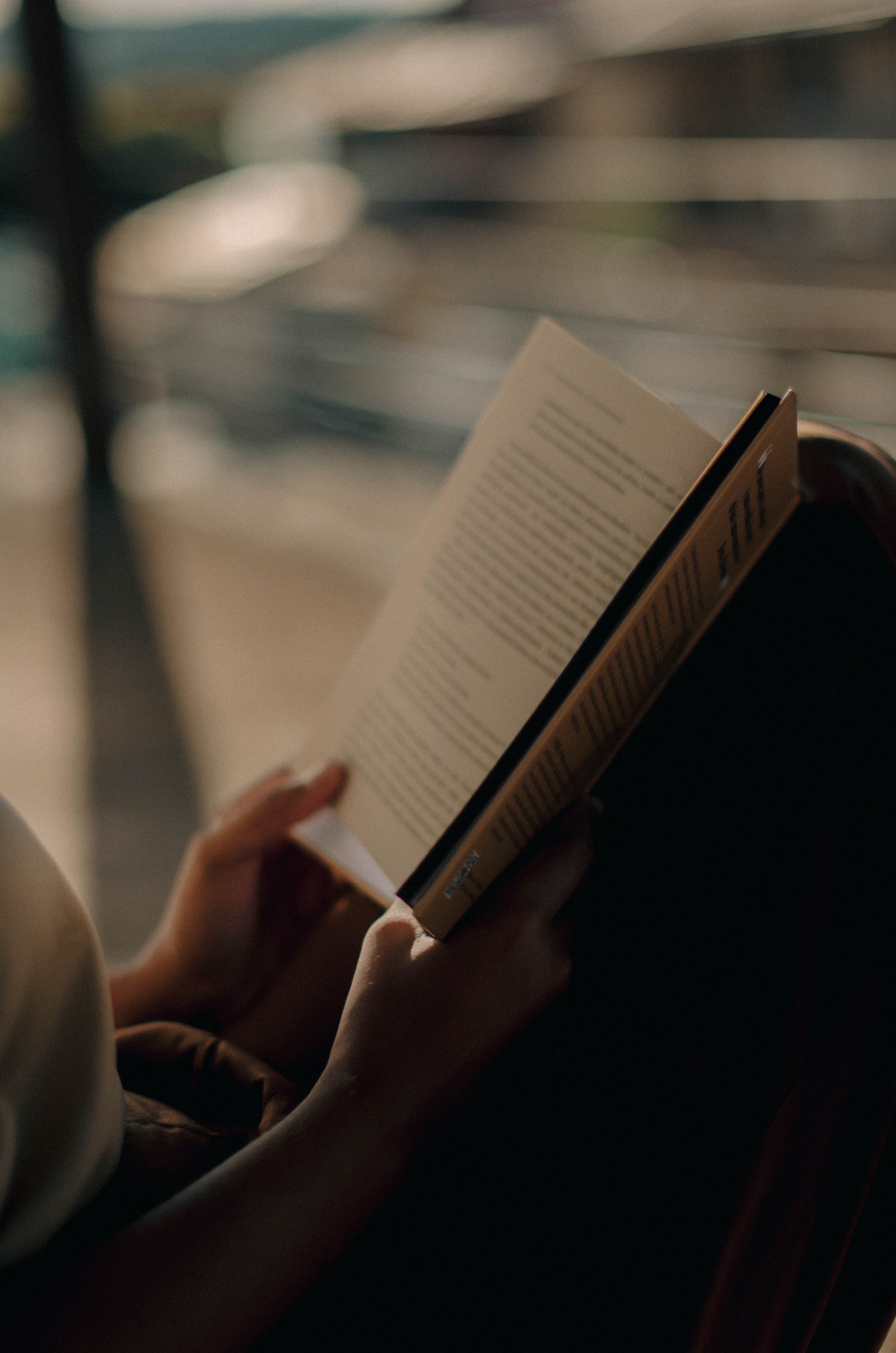 A person reading a book in a chair · Free Stock Photo