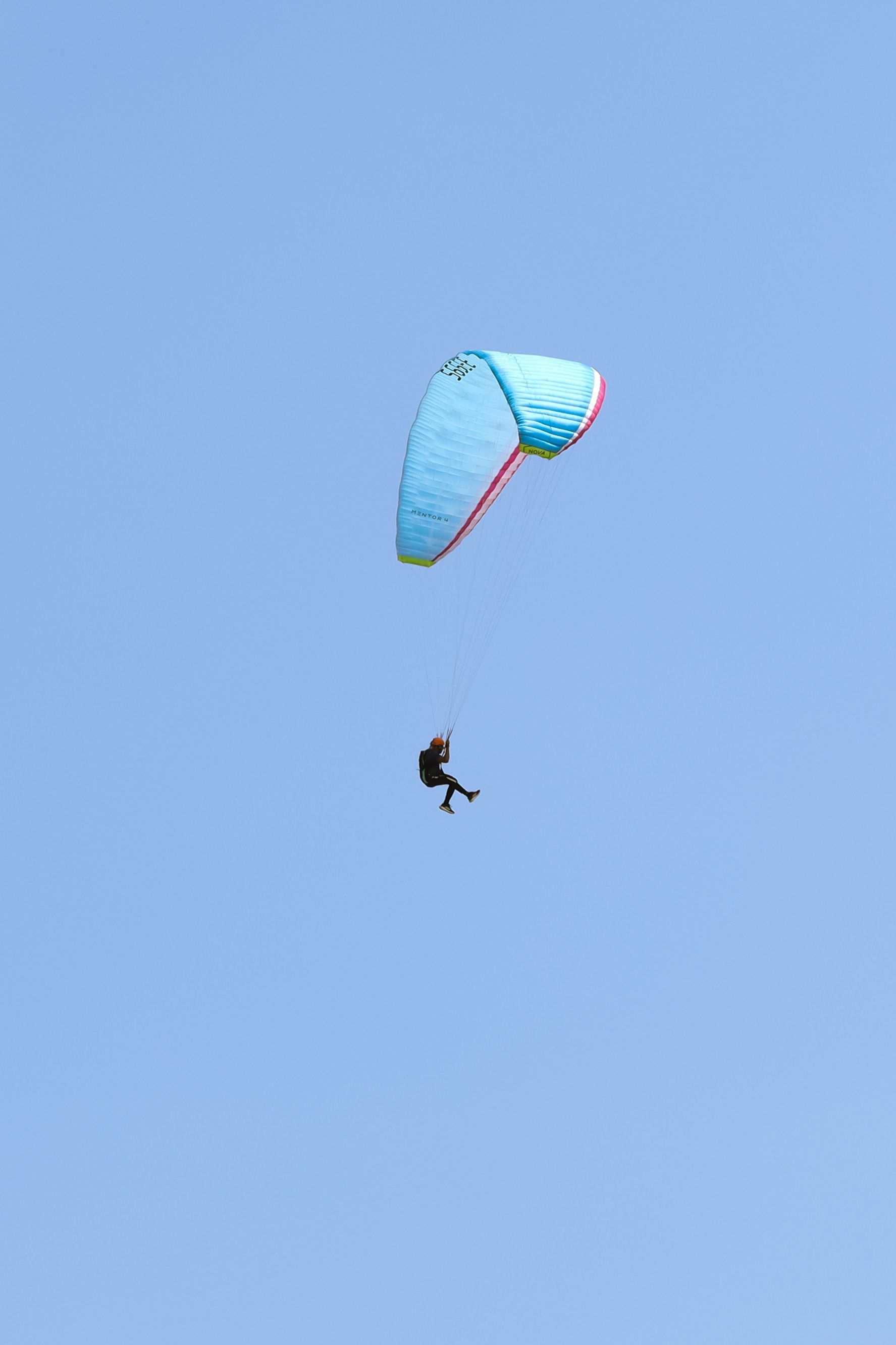Person Flying on Parachute in Blue Sky · Free Stock Photo
