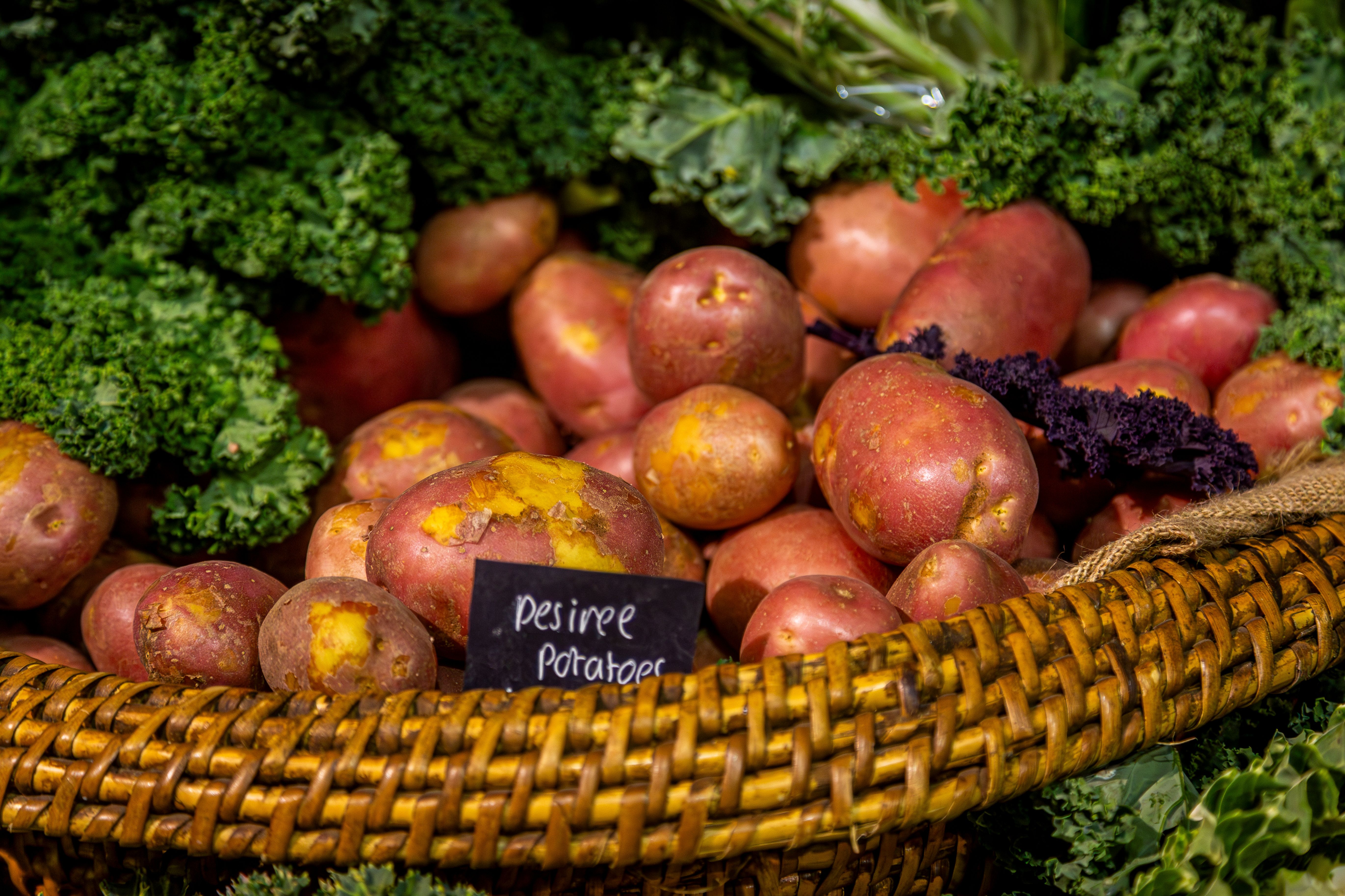 Basket with fresh potatoes placed on counter in market · Free Stock Photo