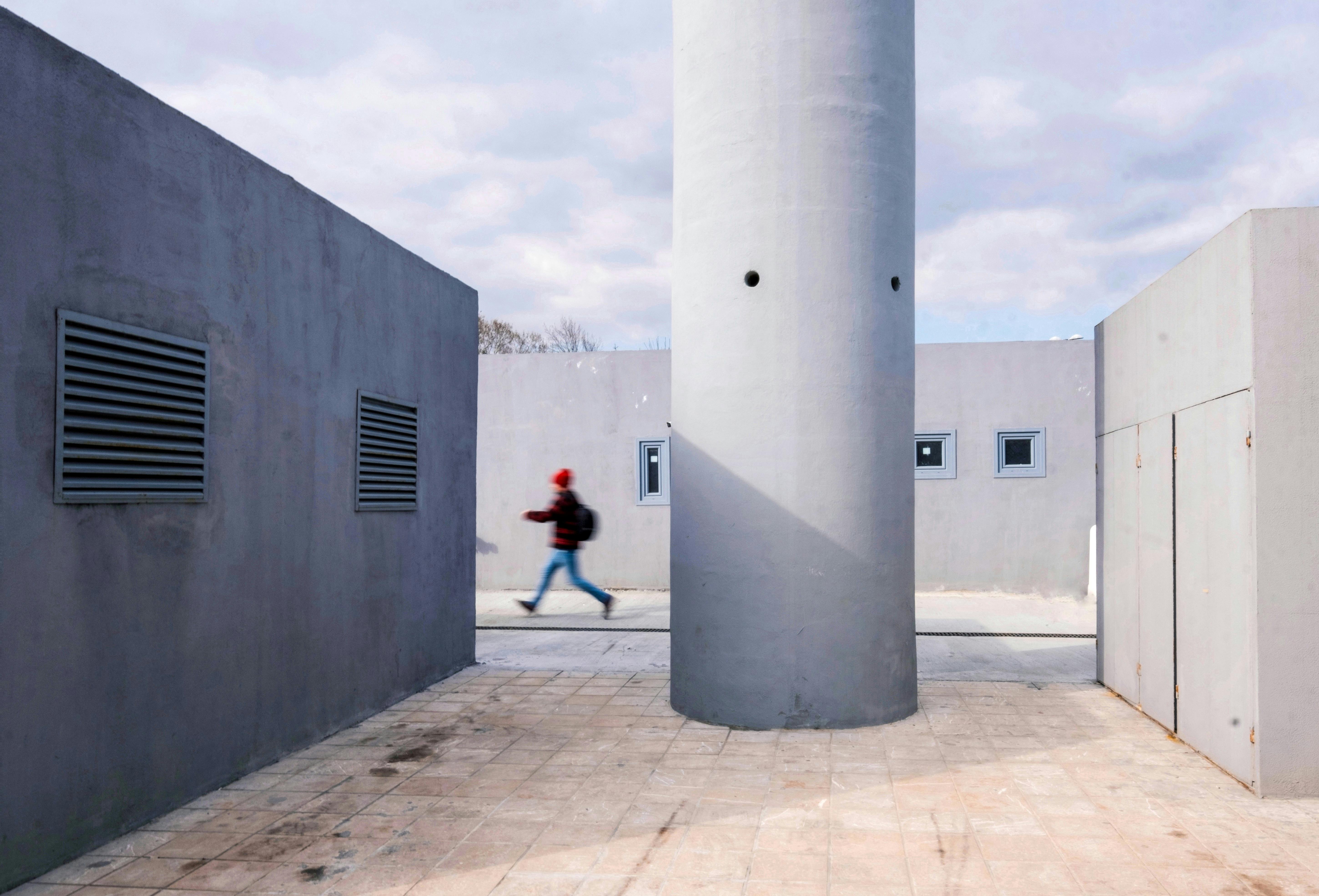 Man Running behind Circular Building · Free Stock Photo