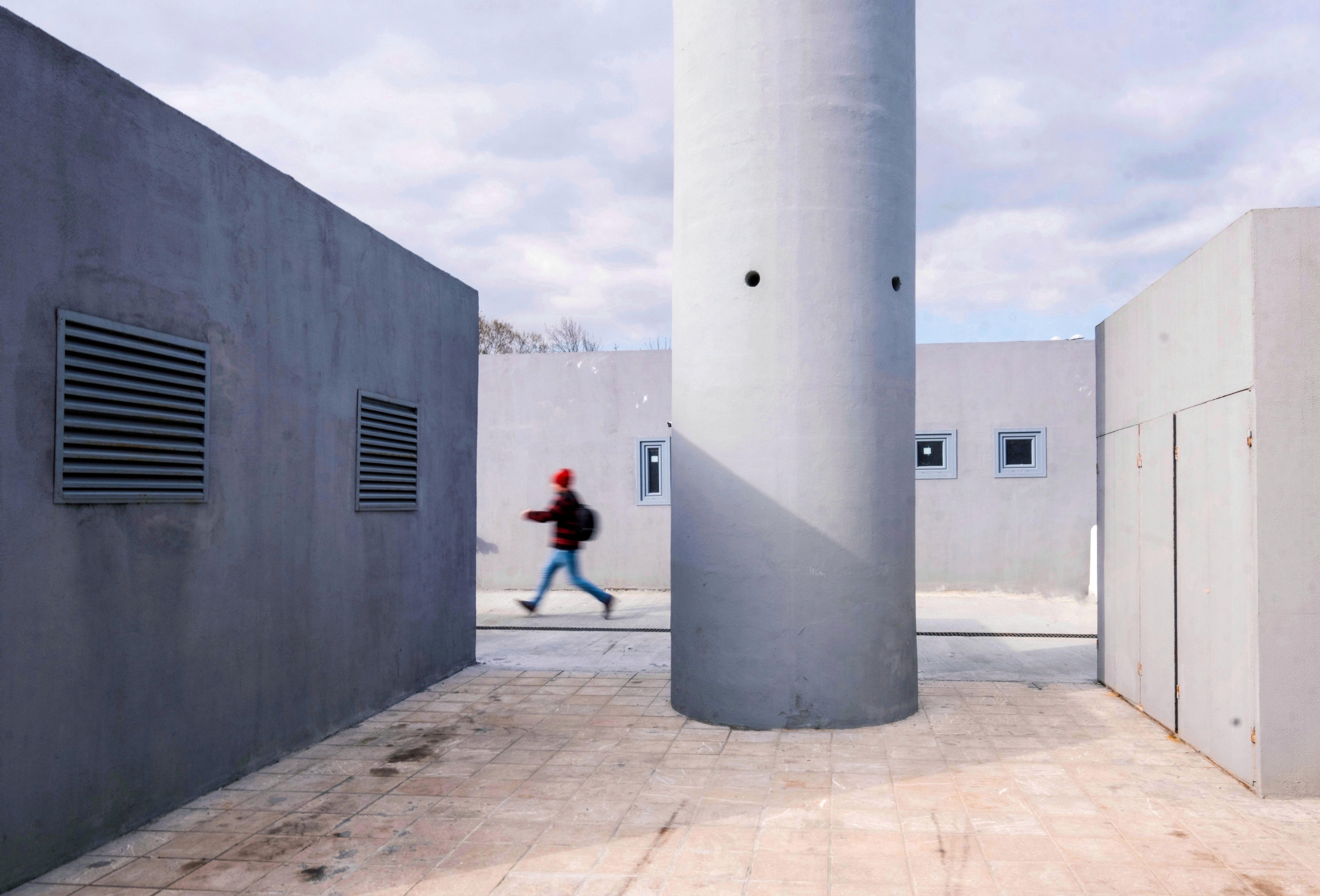 Man Running behind Circular Building · Free Stock Photo