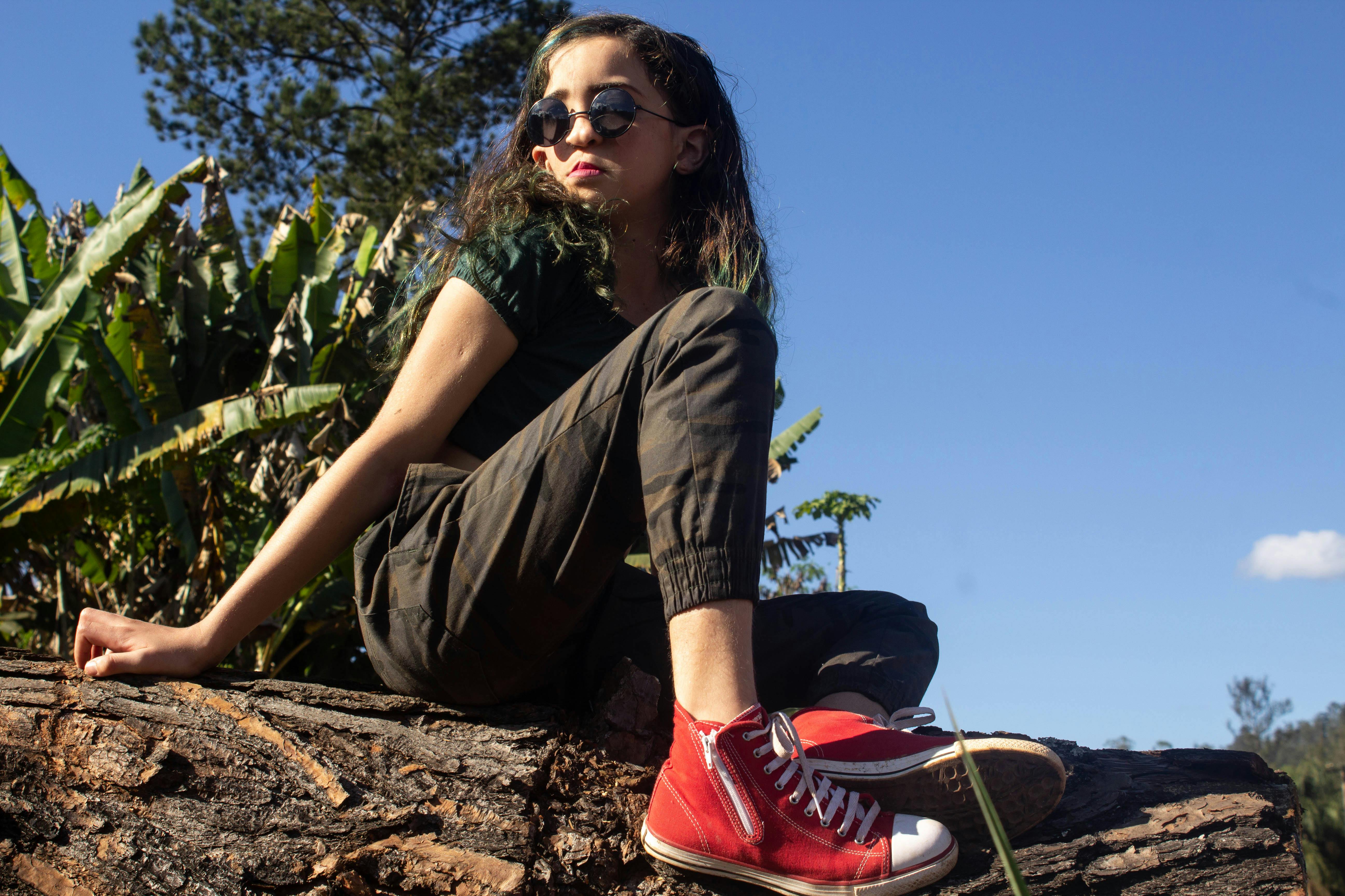 A Girl with Red Converse Posing on a Tree Branch · Free Stock Photo