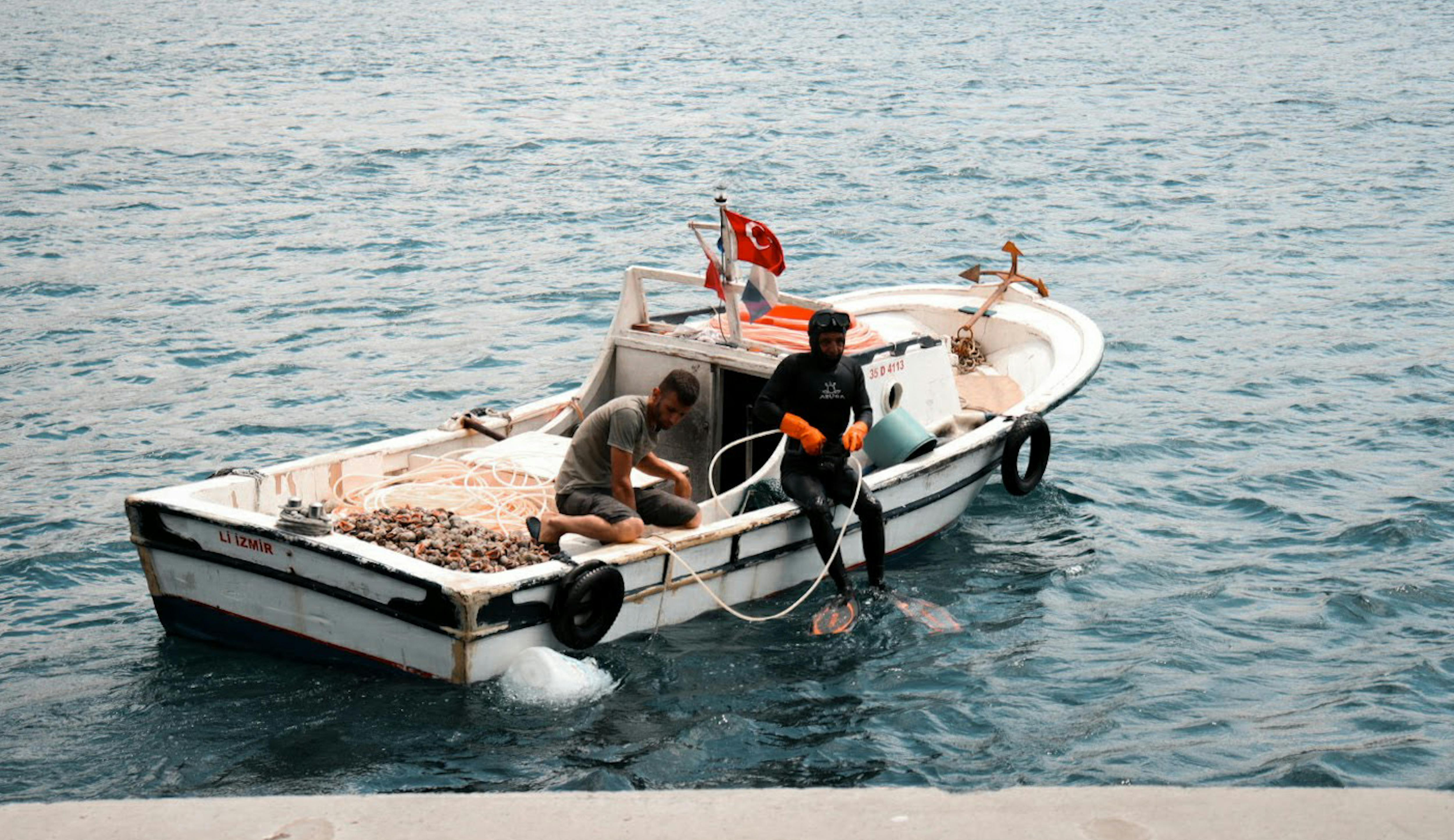 A Man and a Diver Sitting on a Boat · Free Stock Photo