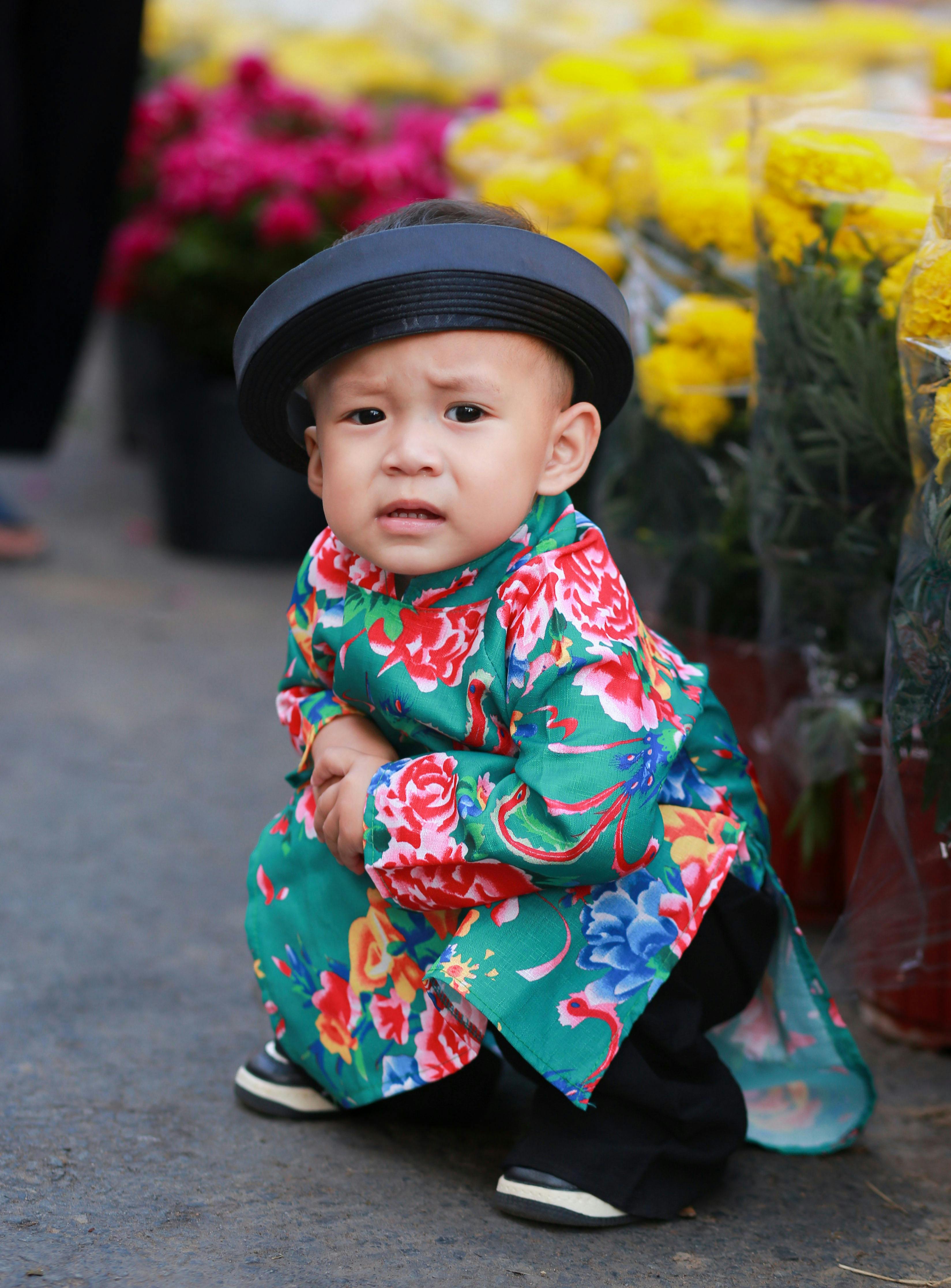 Portrait of a Chinese Boy Crouching in the Street · Free Stock Photo