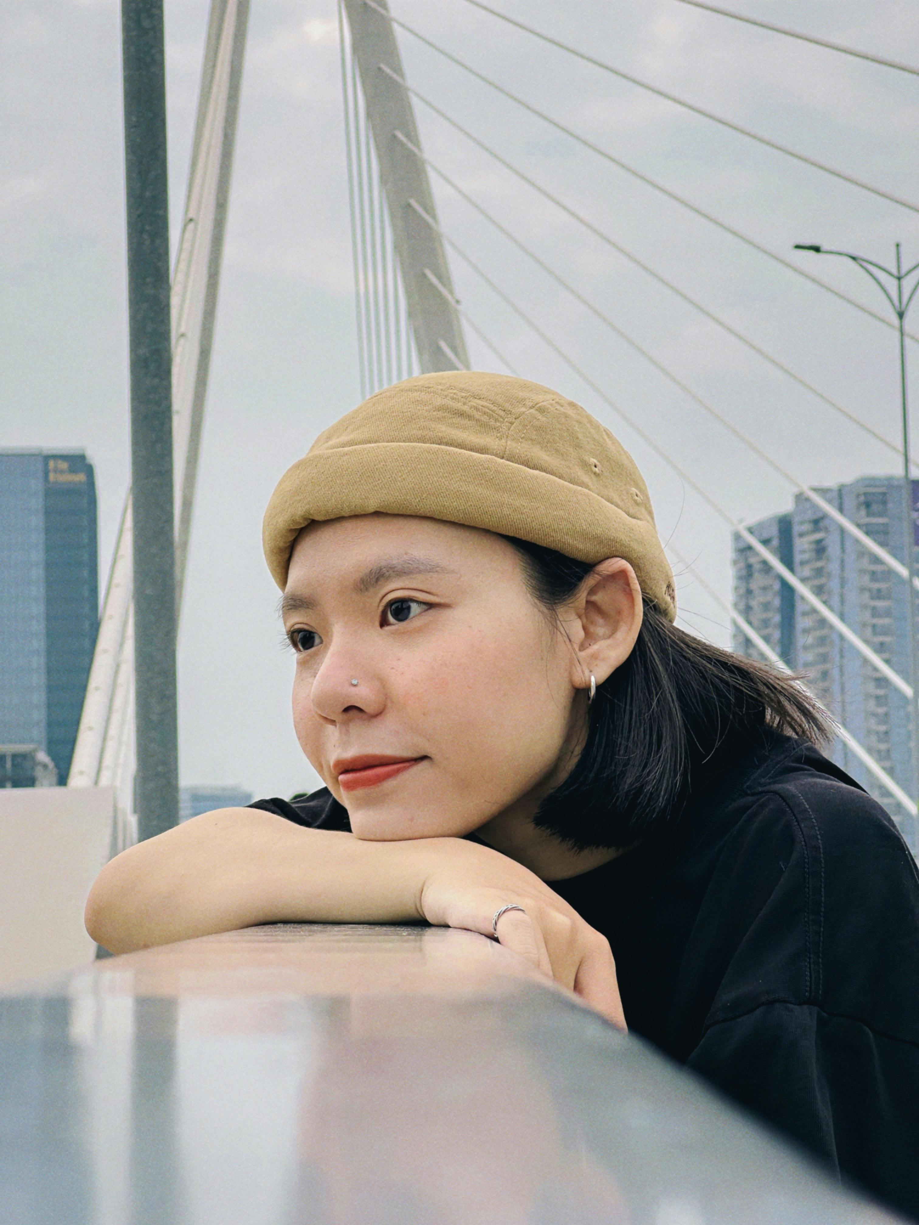Woman with Cap on a Suspension Bridge · Free Stock Photo