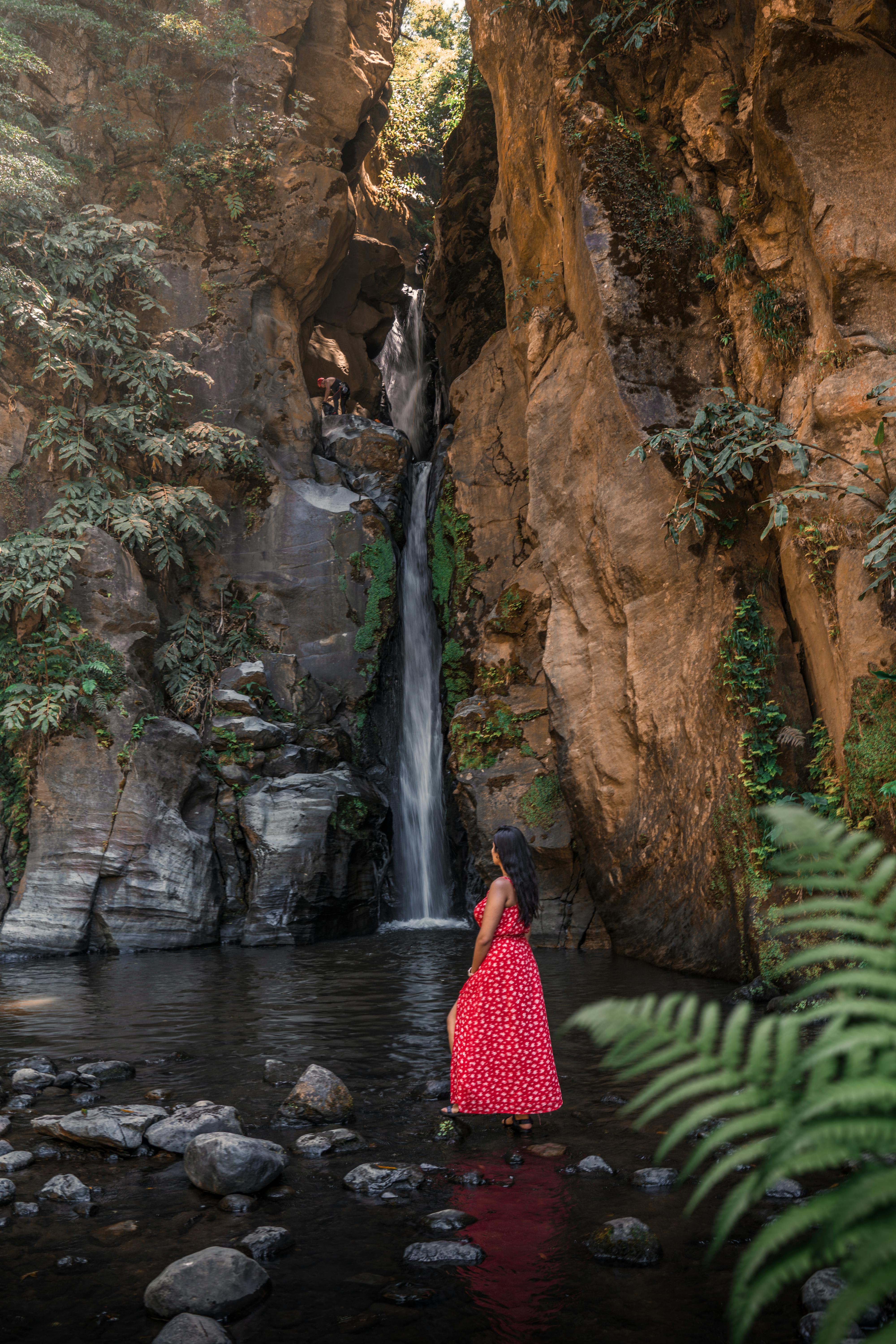 Person in Jacket Standing under Waterfall · Free Stock Photo