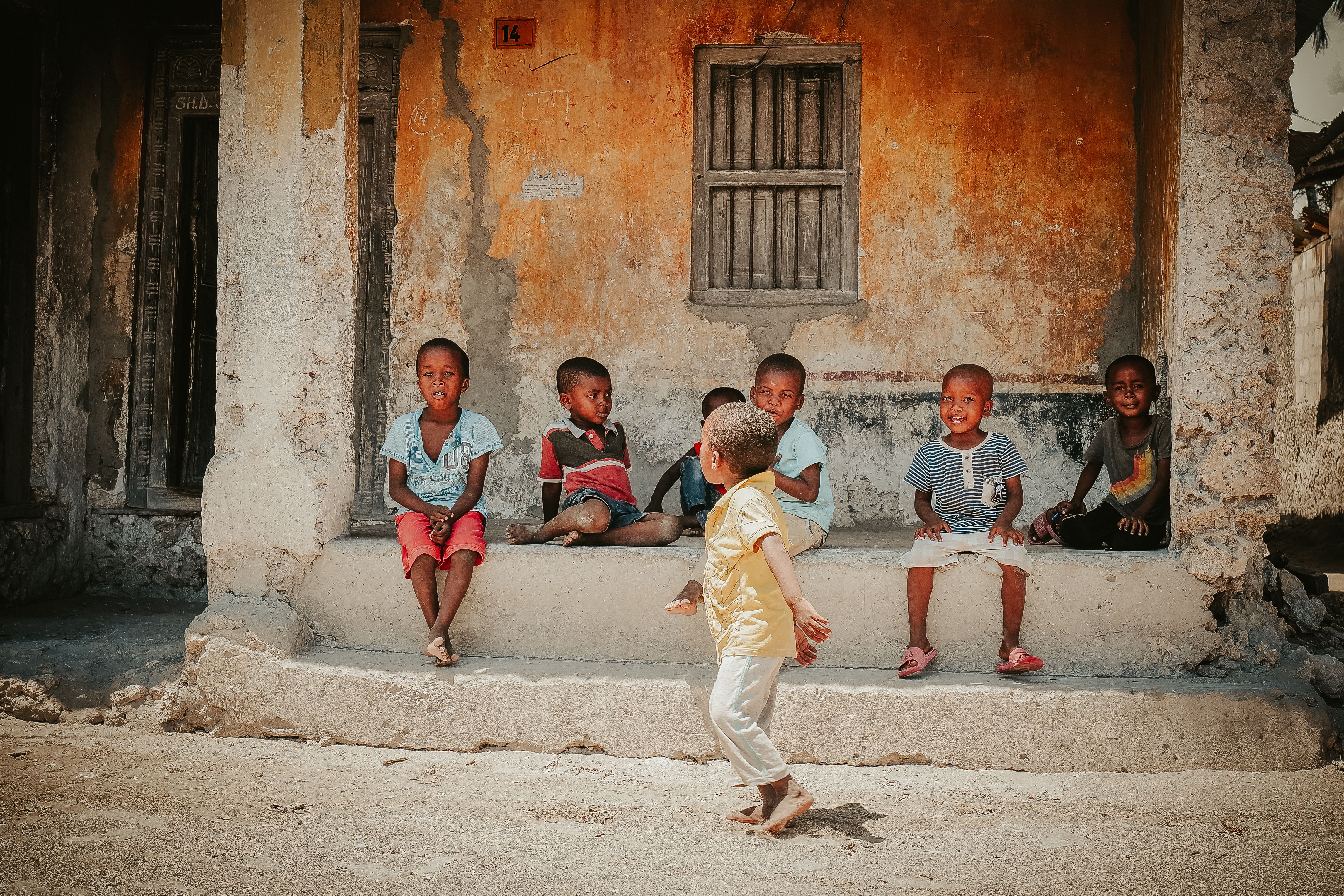 A Group of Children Sitting on Steps Outside of a Building · Free Stock ...