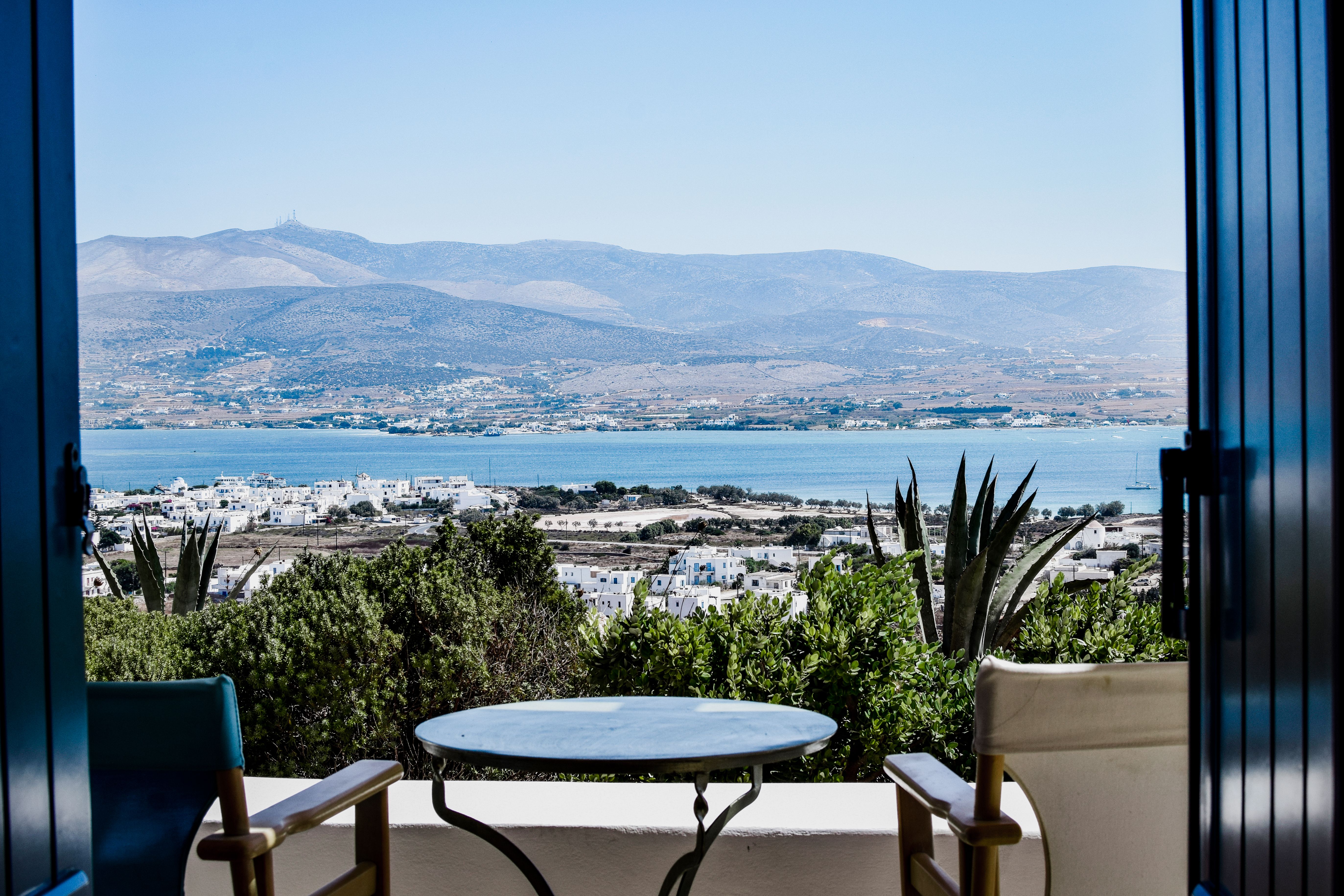 Table and Chairs on Balcony with Sea Coast and Hills behind · Free ...