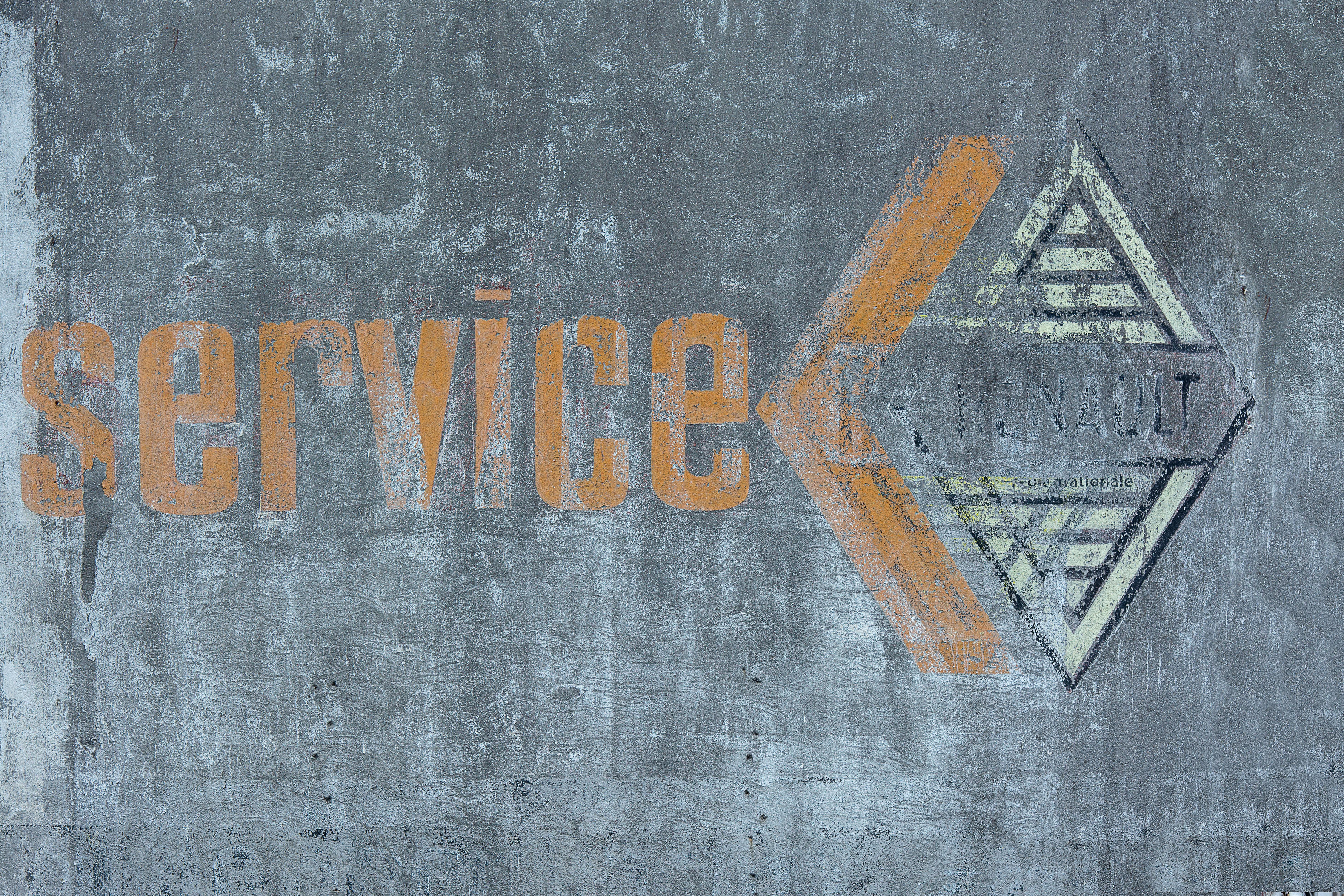 Wiped Text and Logo on Gray Wall · Free Stock Photo