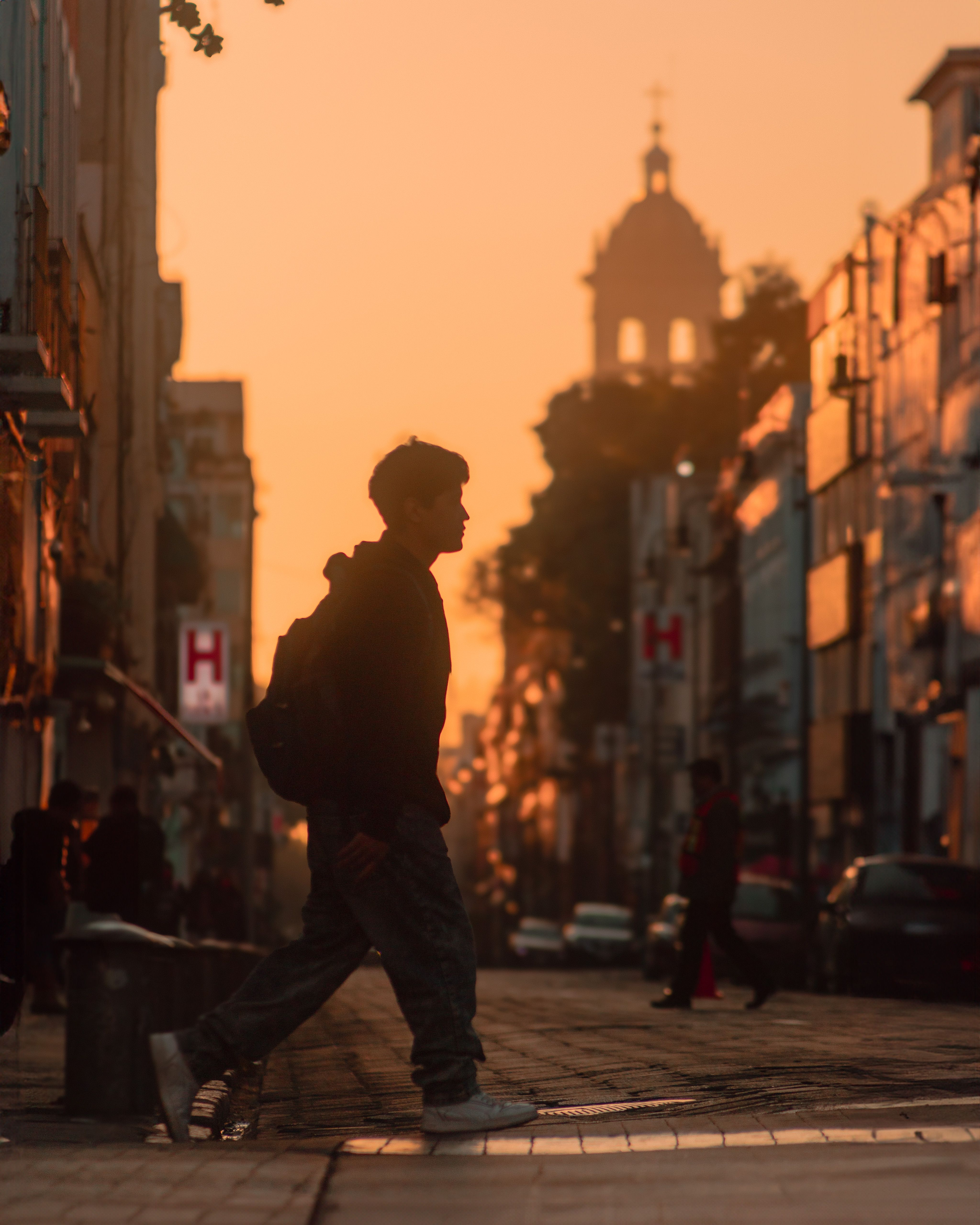 Man Crossing Street in City at Sunset · Free Stock Photo