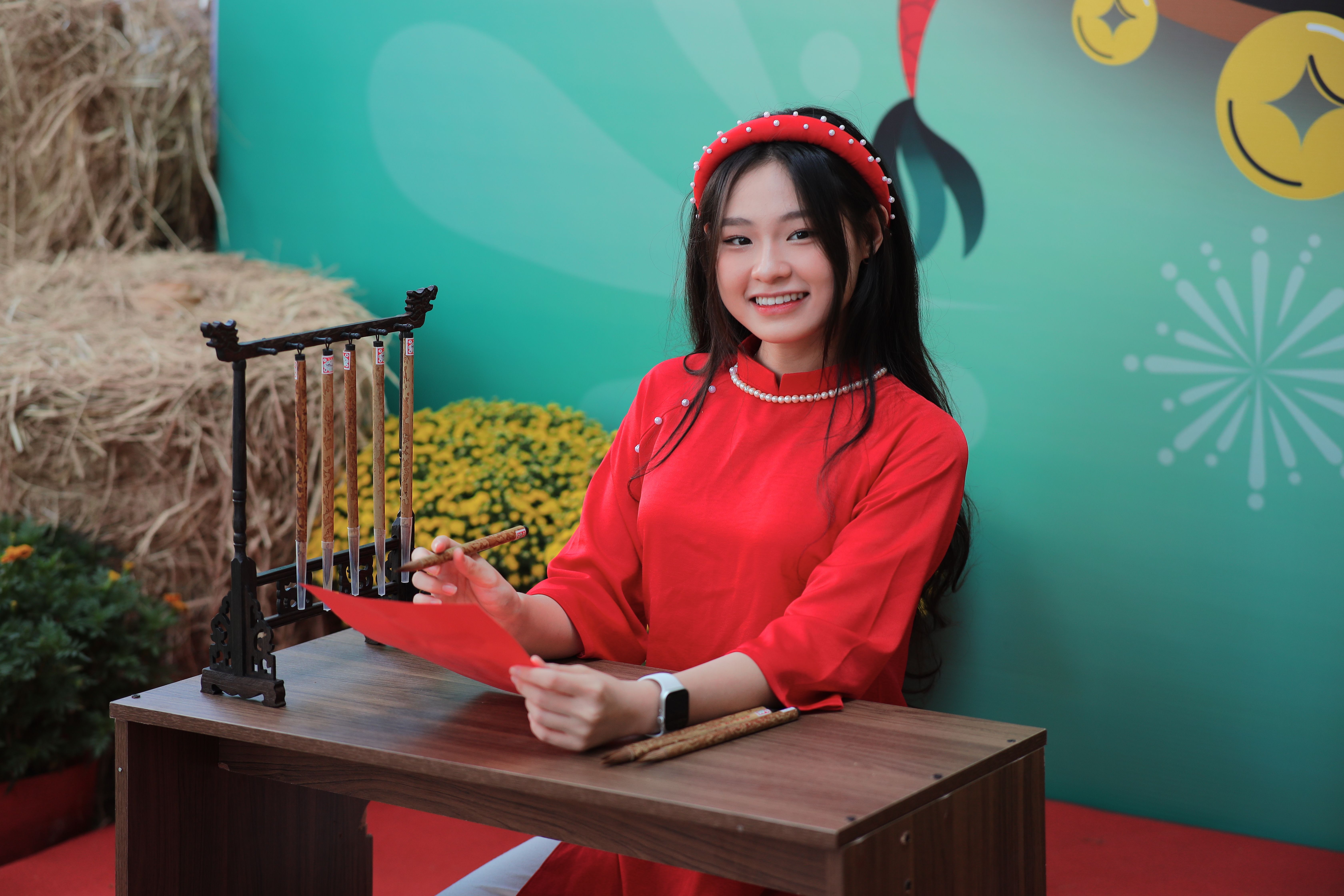 Smiling Young Woman in a Red Traditional Dress at a Calligraphy Table ...